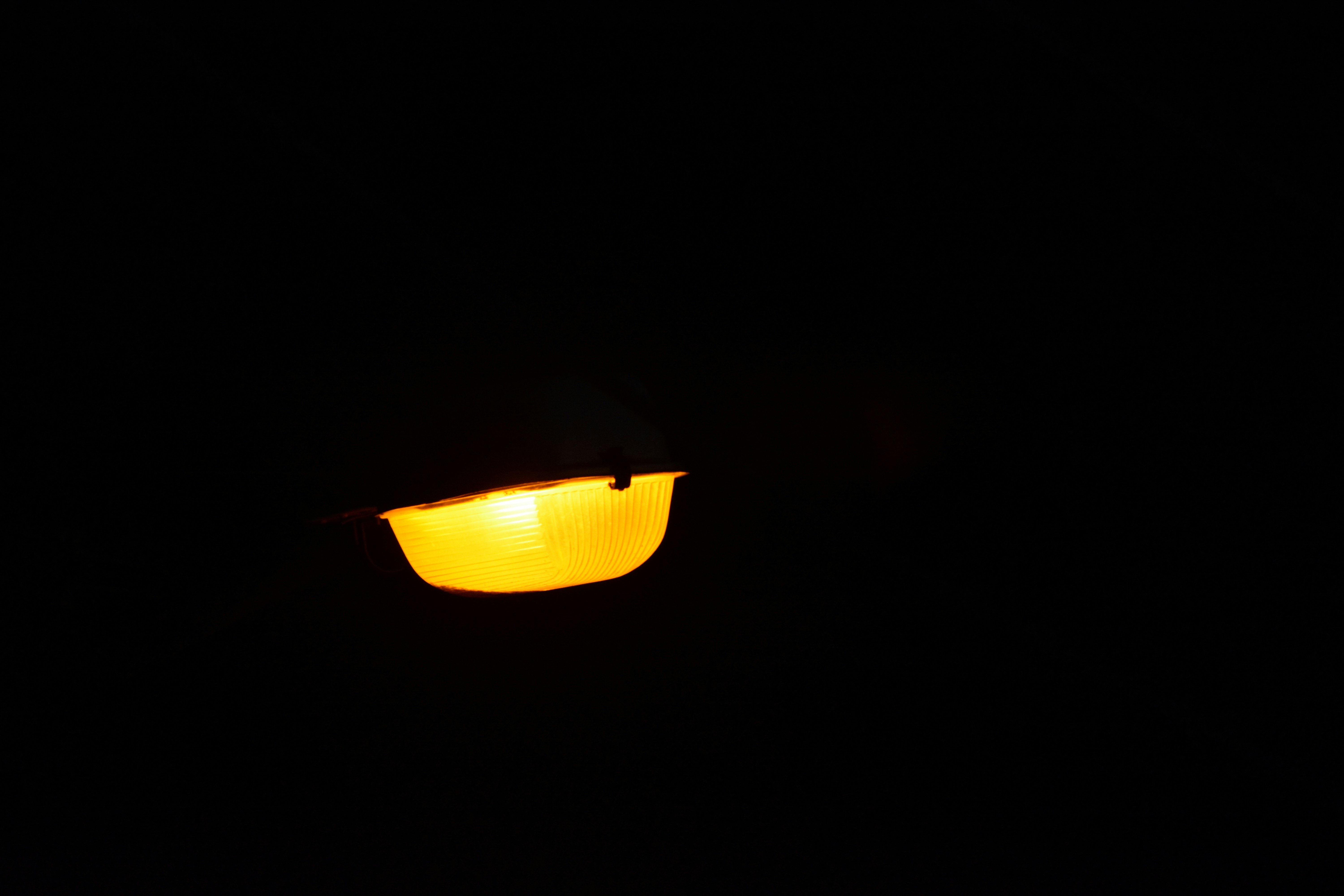 Glowing Low-Light Glint: A Single Amber Halo in Darkness