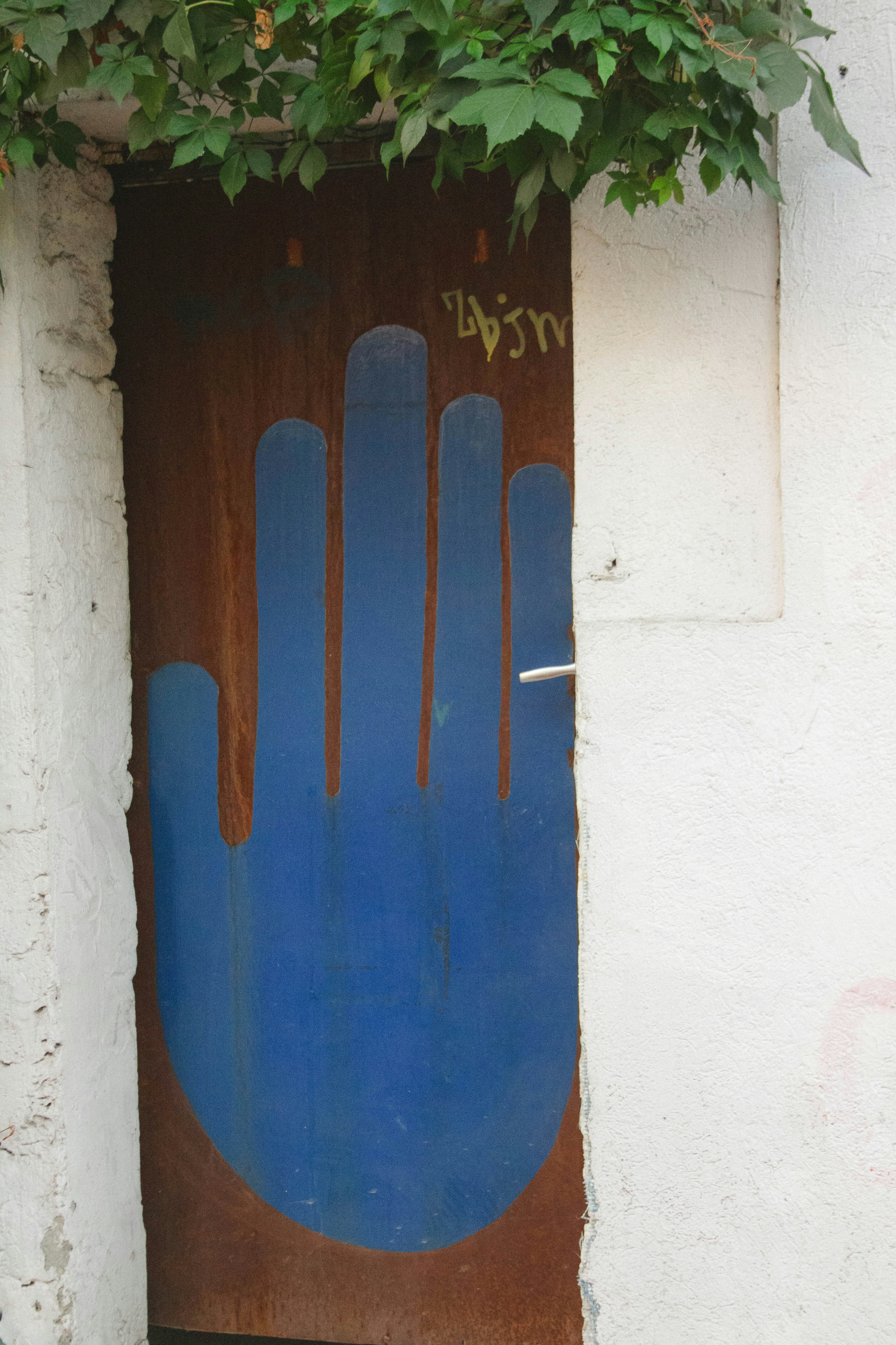 Azure Handprint Gate on a Weathered Door