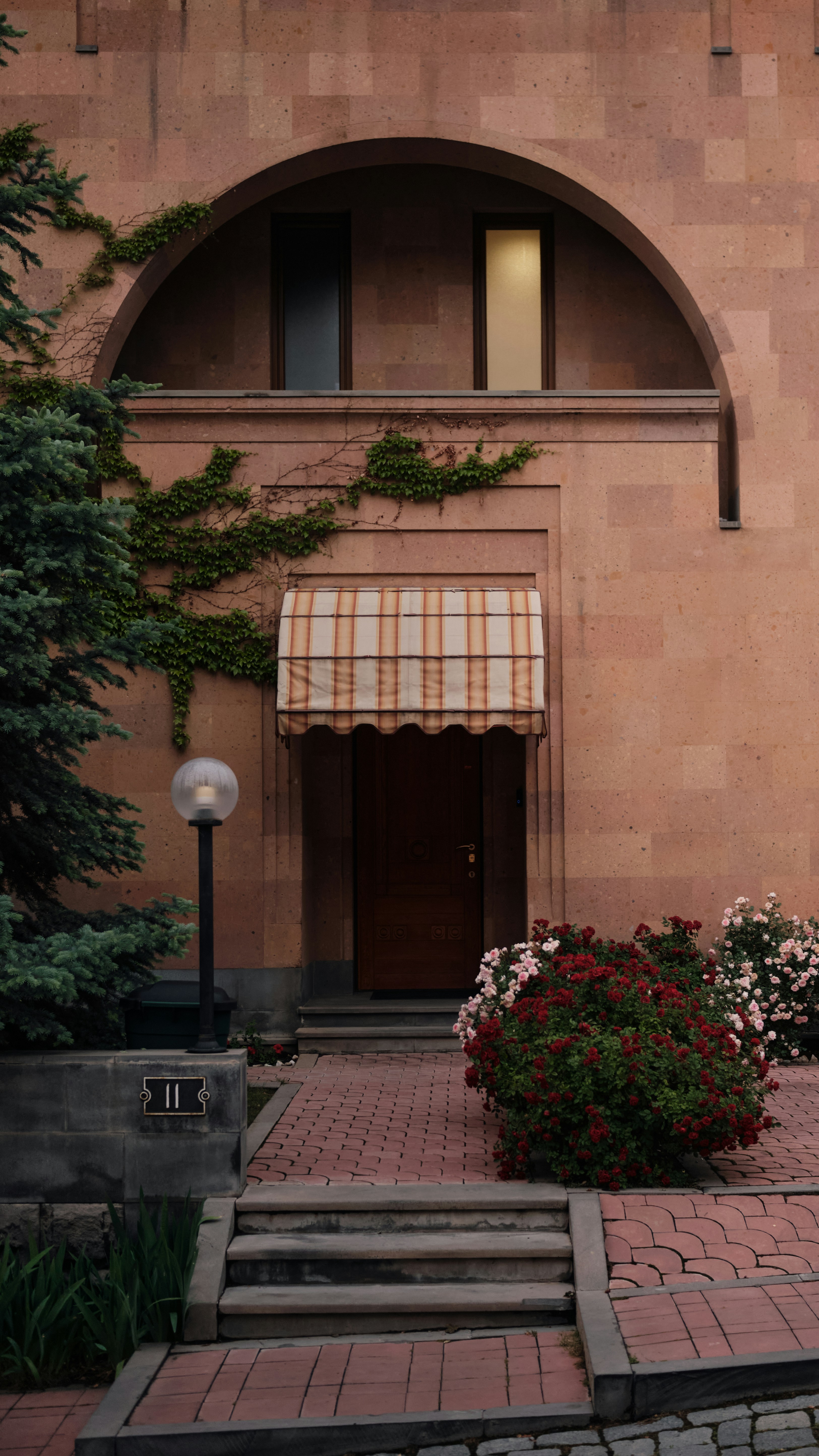 Ivy Archway with Striped Canopy: A Quiet Doorway in Brick