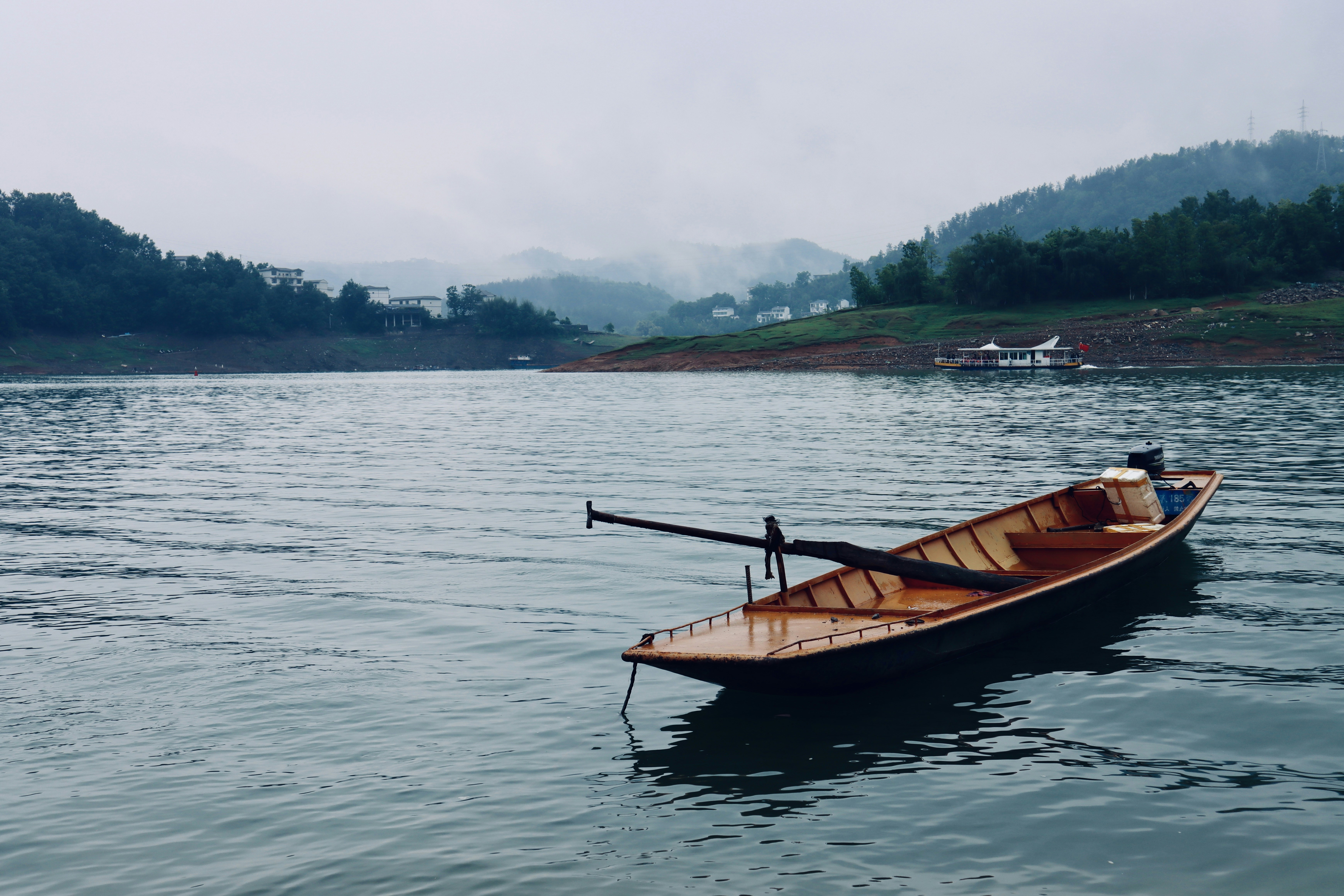 Driftwood Skiff on a Quiet Lake: Misty Hills as Backdrop