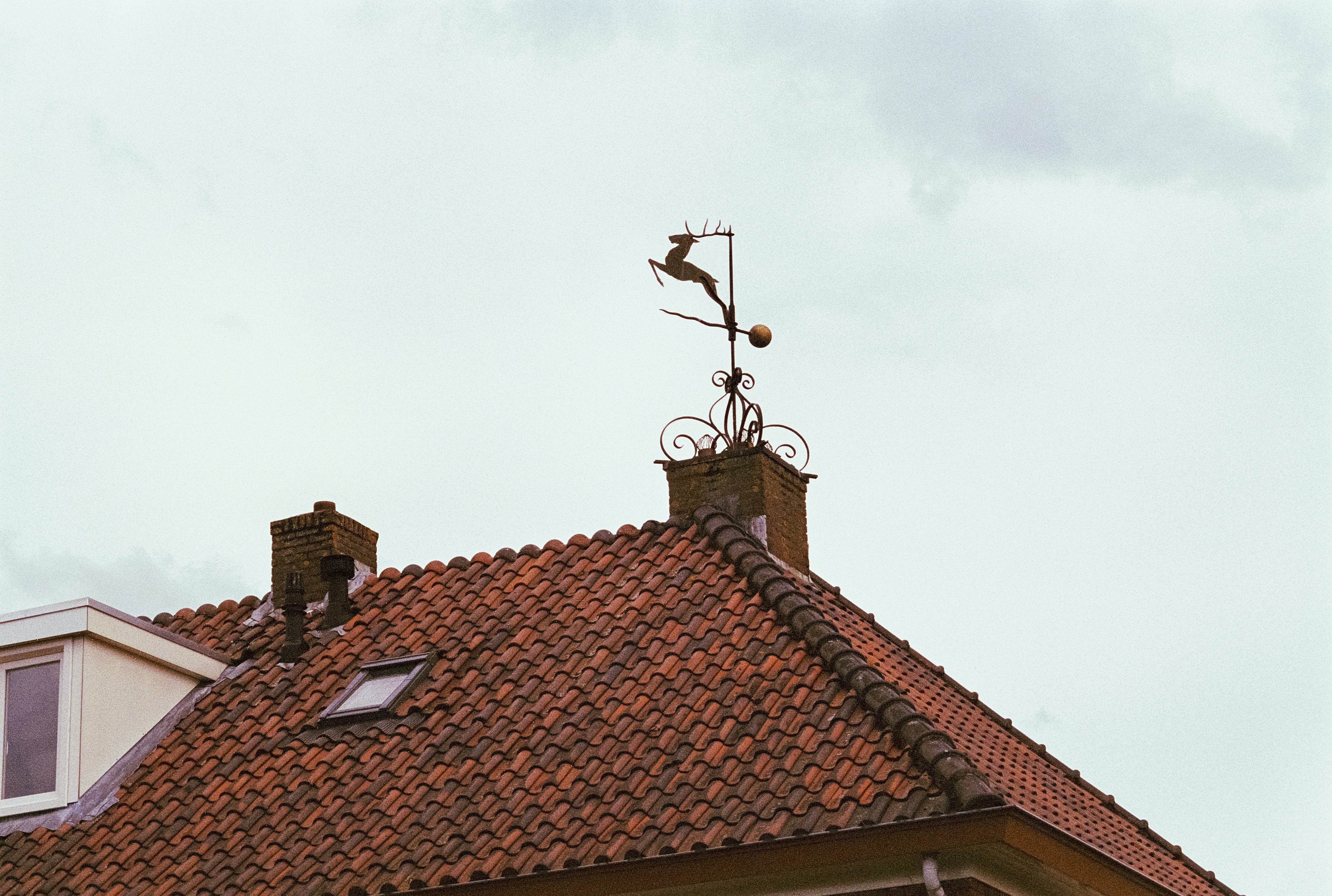 Weather Vane at the Crest of a Red-Tiled Roof