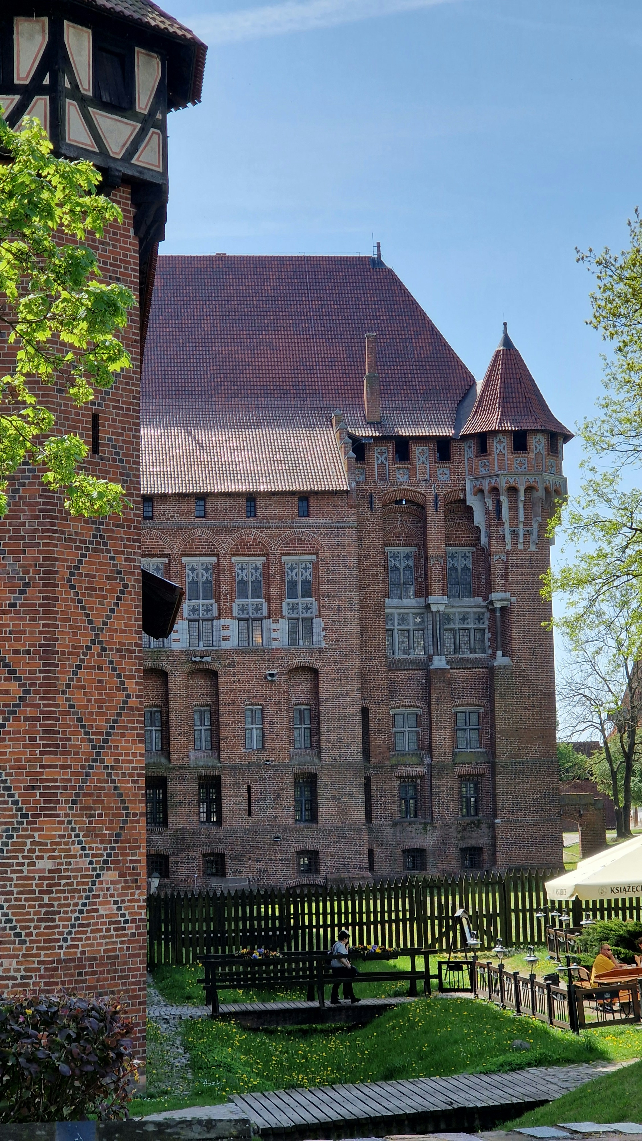 Sunlit Brick Castle Courtyard with Turrets and Quiet Benches