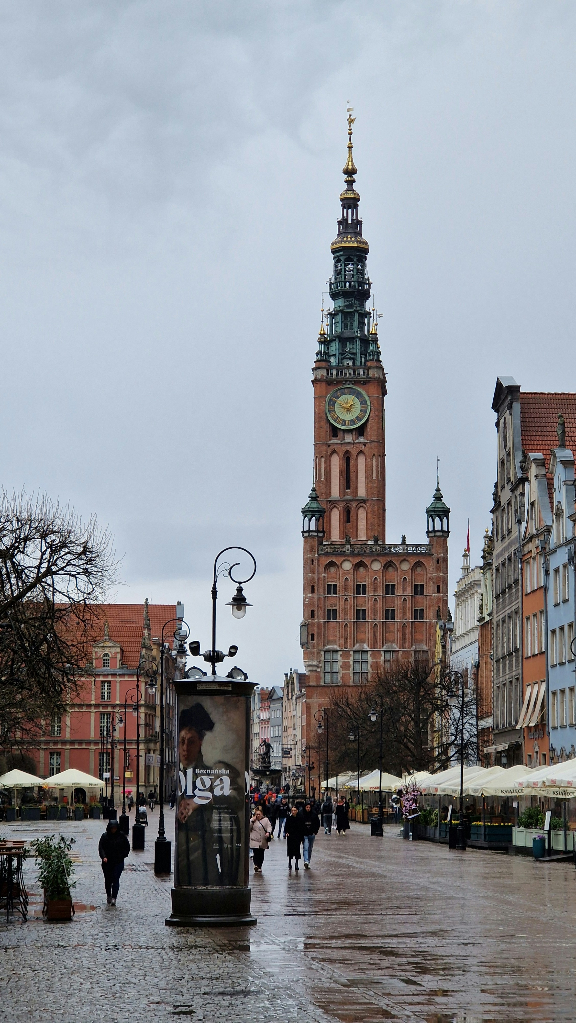 Brick Clock Tower Rises Over a Glistening European Promenade