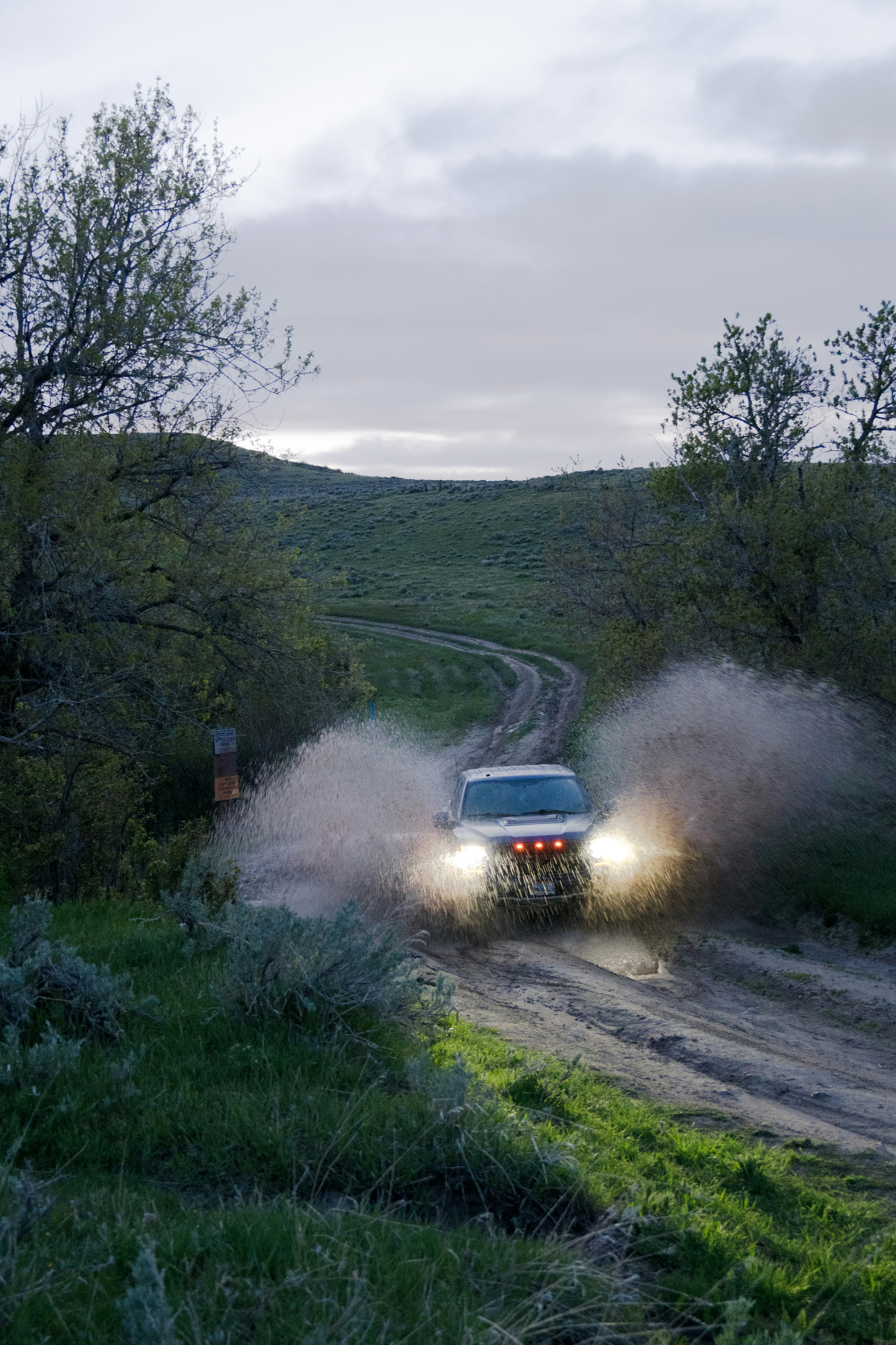 Mud-Splashed SUV Conquers a Winding Dirt Road at Dusk
