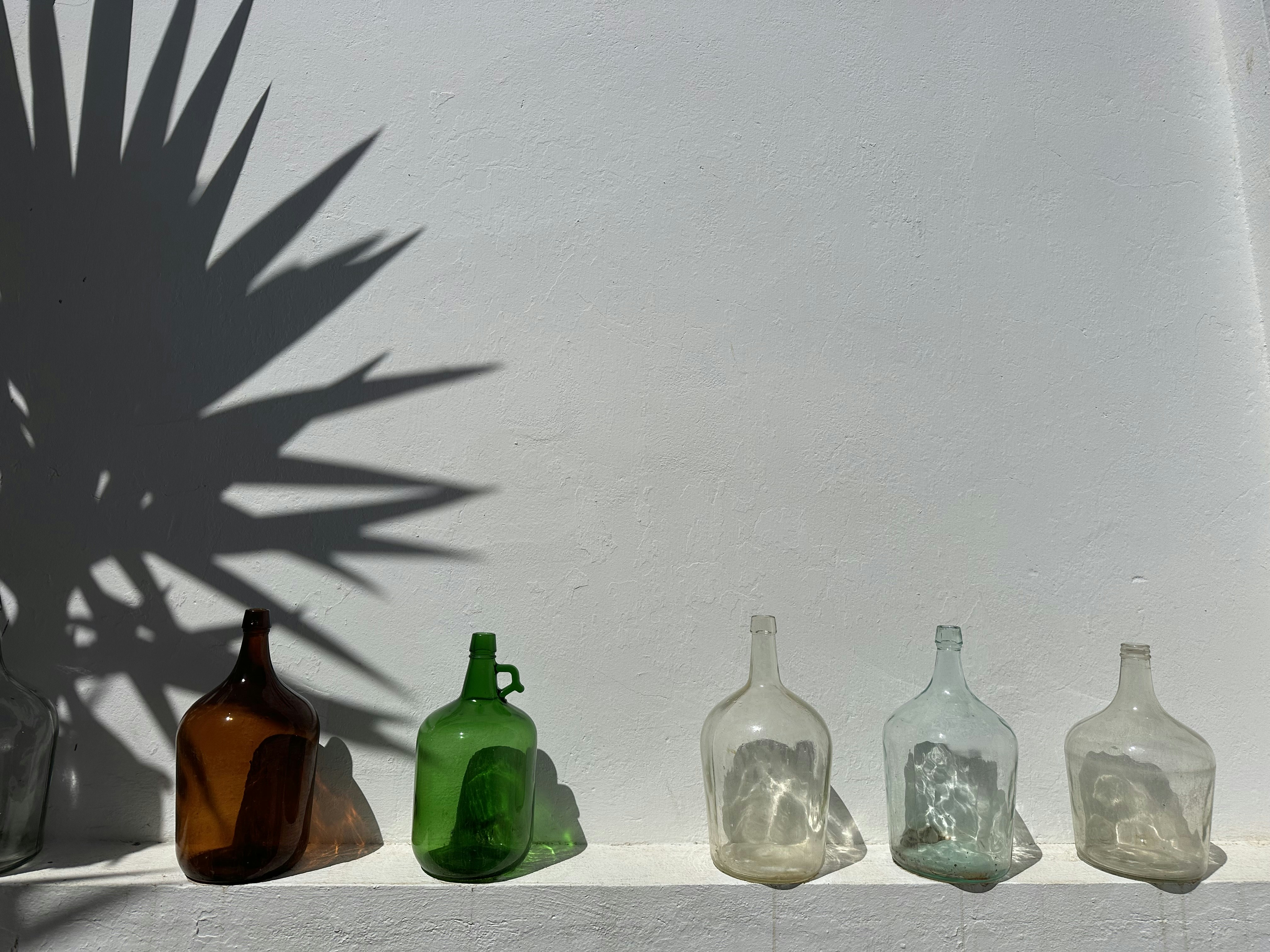 Emerald Bottle in a Row: Light, Shadow, and Quiet Color on White