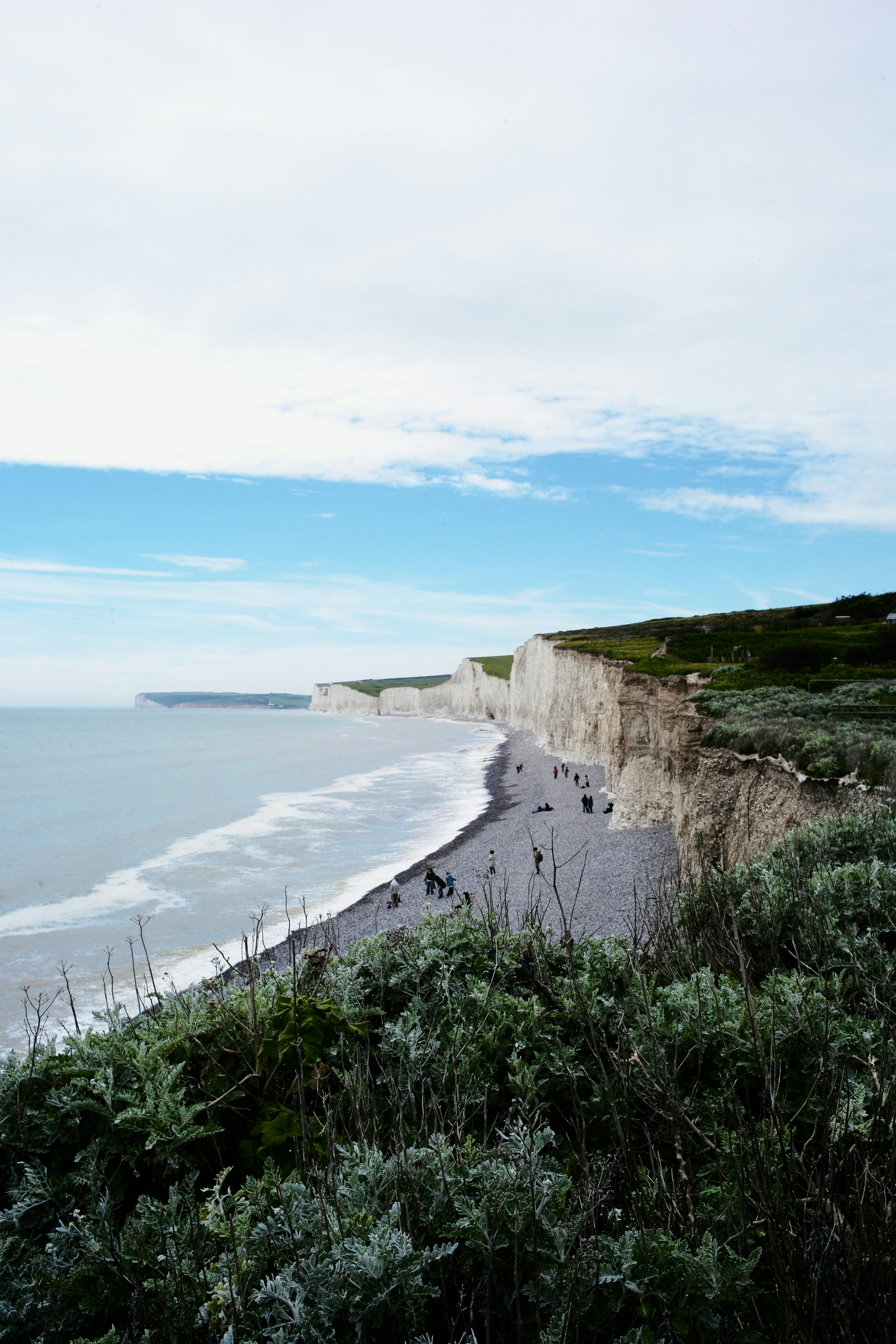 A view of a beach with a cliff in the background photo – Free White ...