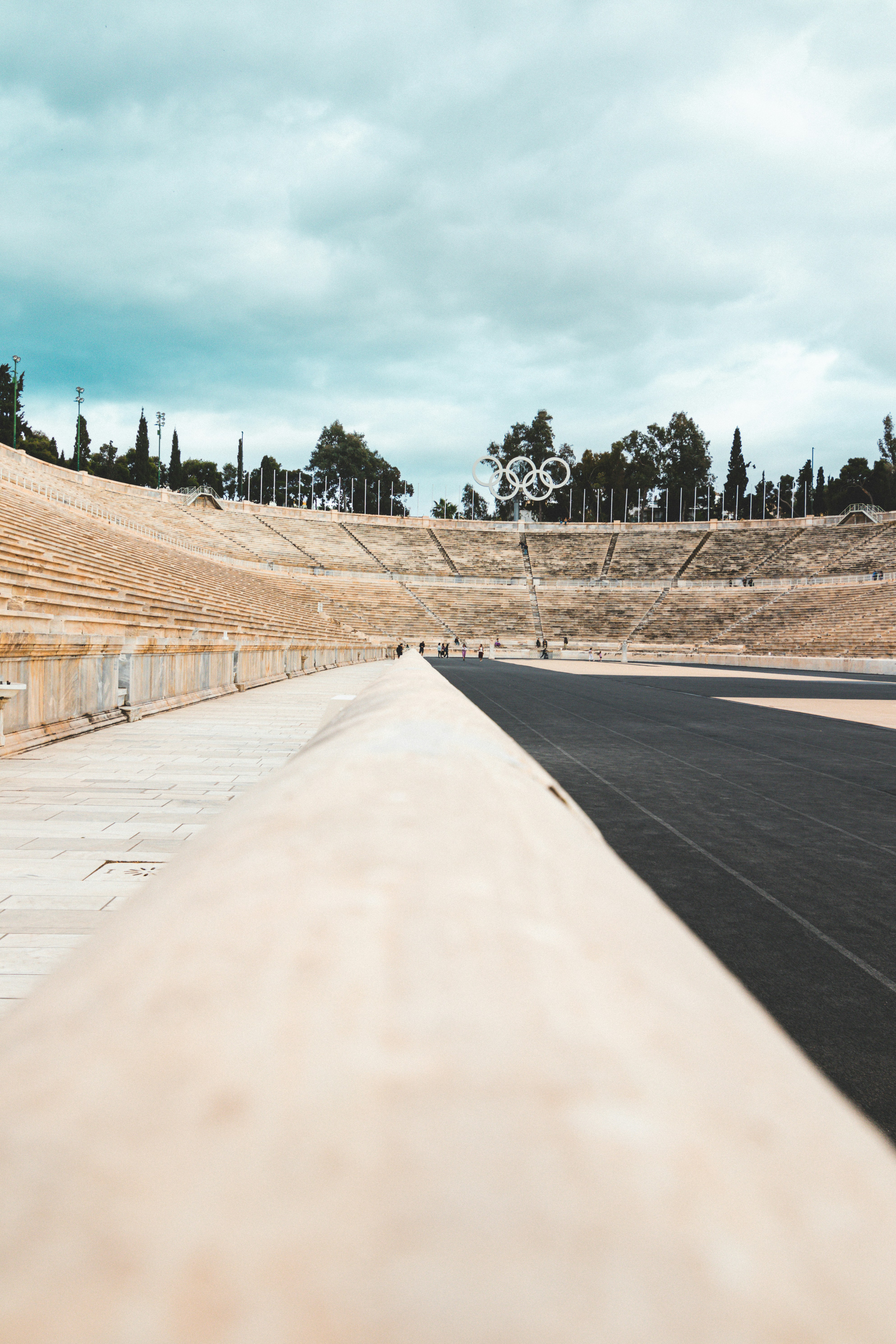 Vanishing Rails Toward the Olympic Rings Over an Empty Amphitheater
