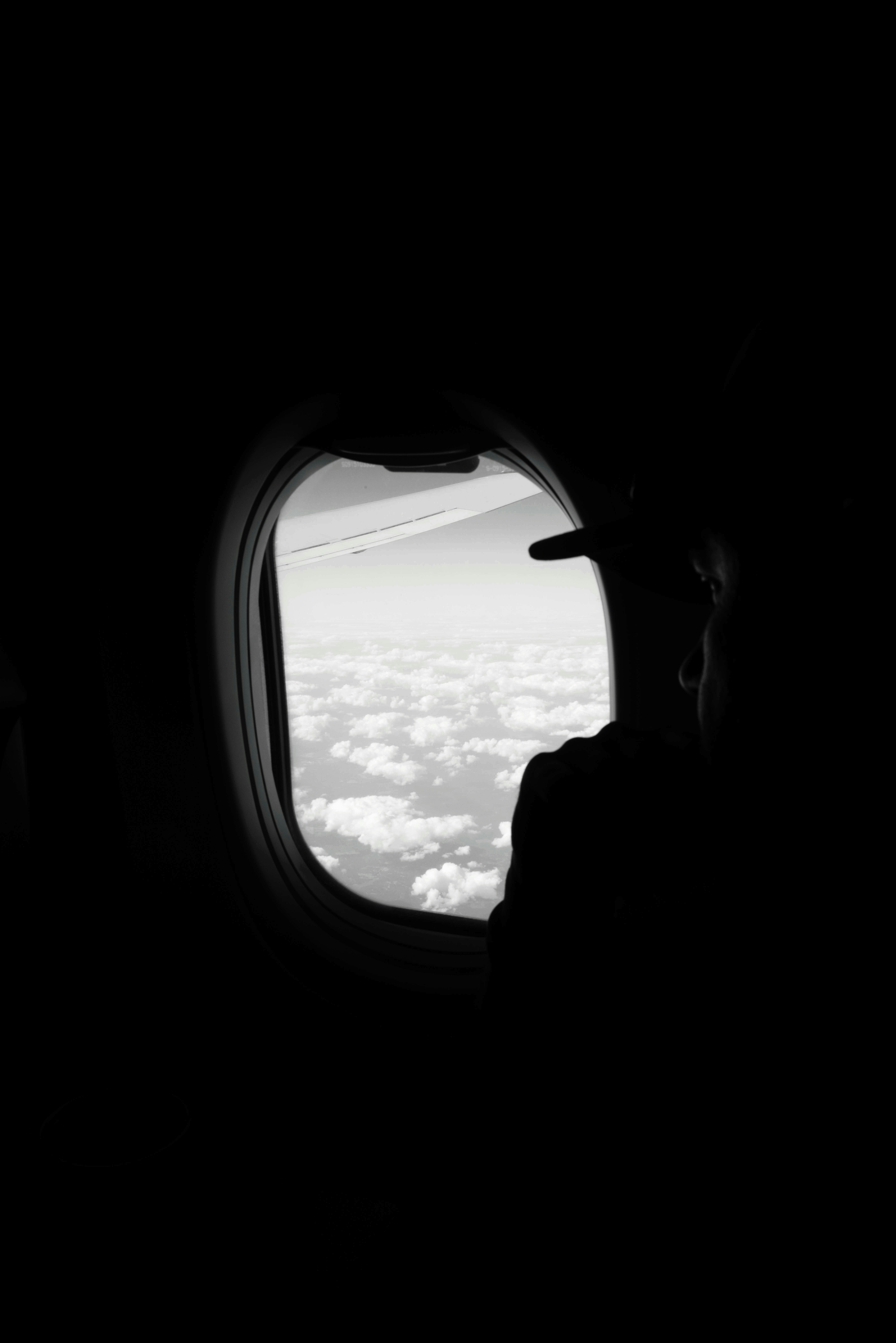 A person looking out of an airplane window photo – Free Airplane Image ...