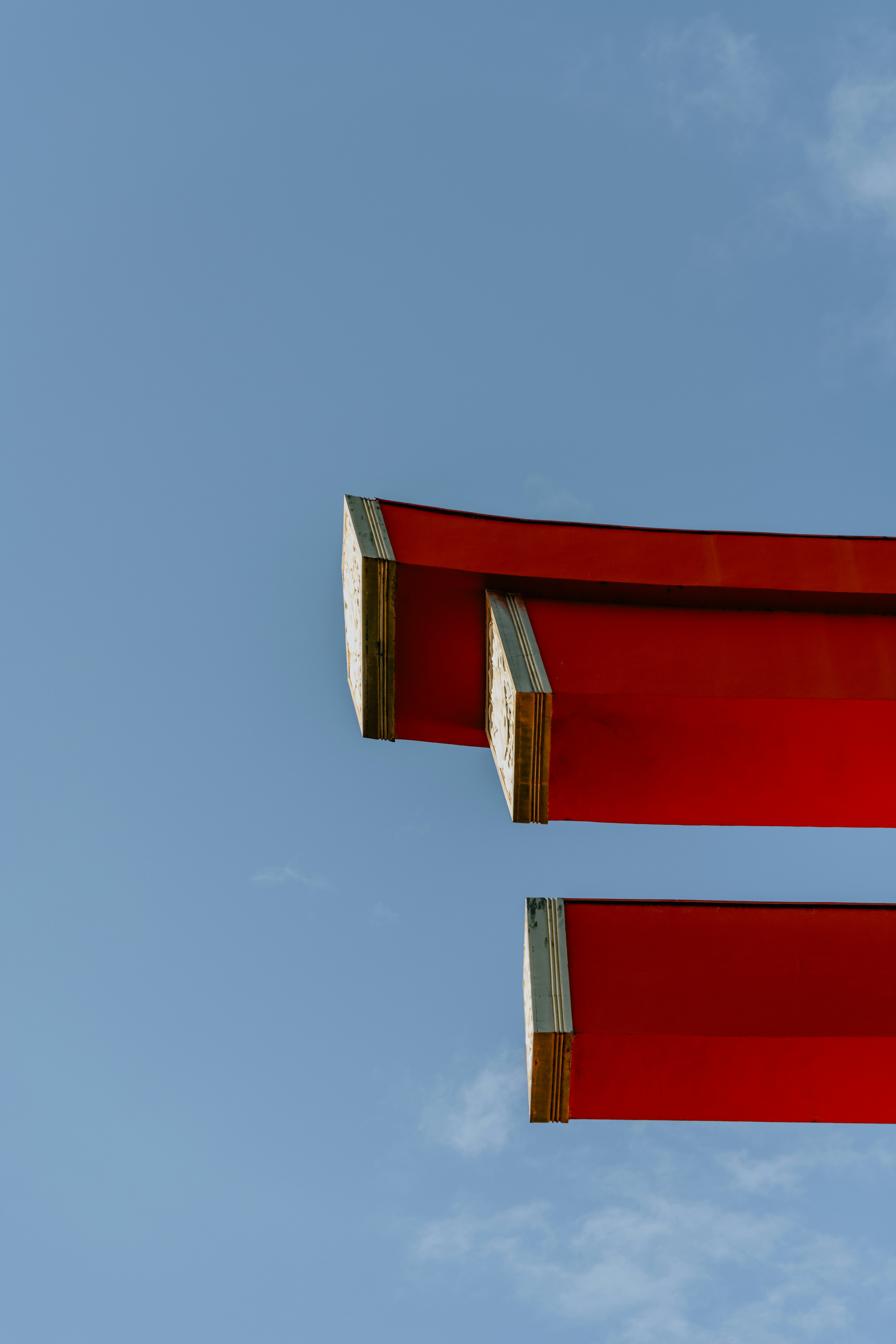 Red Torii Fragments Hovering Across a Clear Blue Sky