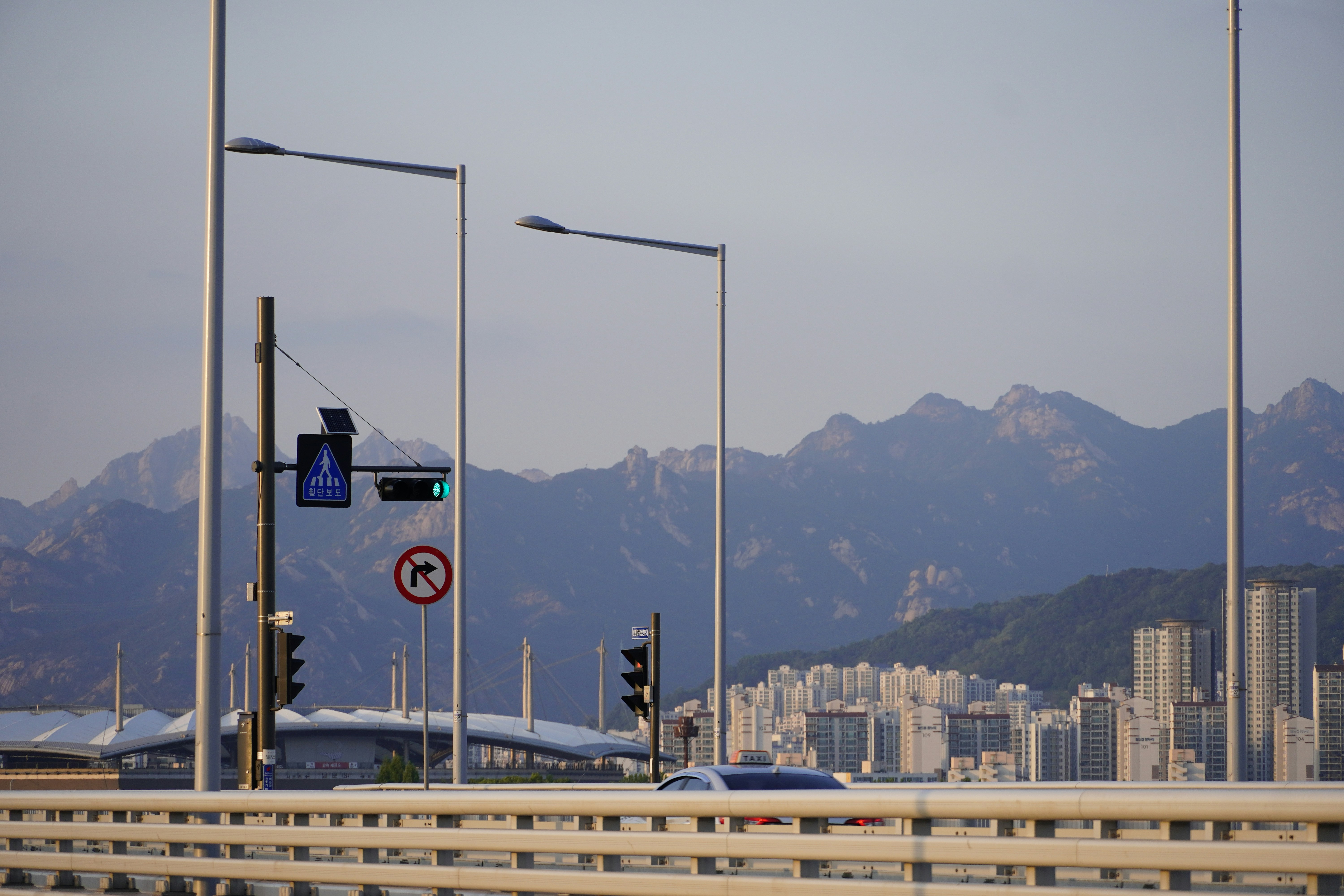 Traffic Signal Lanterns Framing a Mountain City Horizon