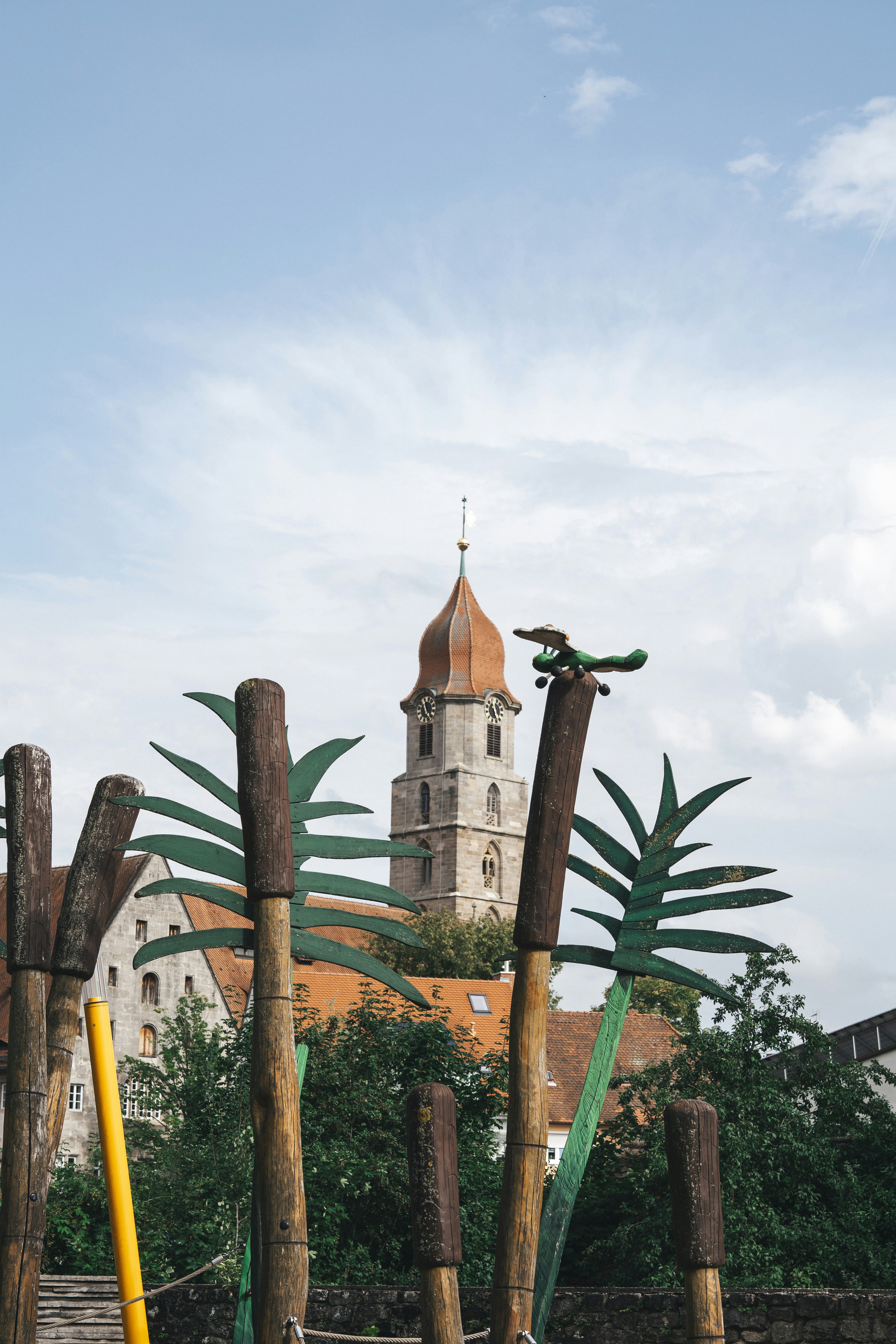 Timber Sentinels Framing a Copper-Topped Church Tower