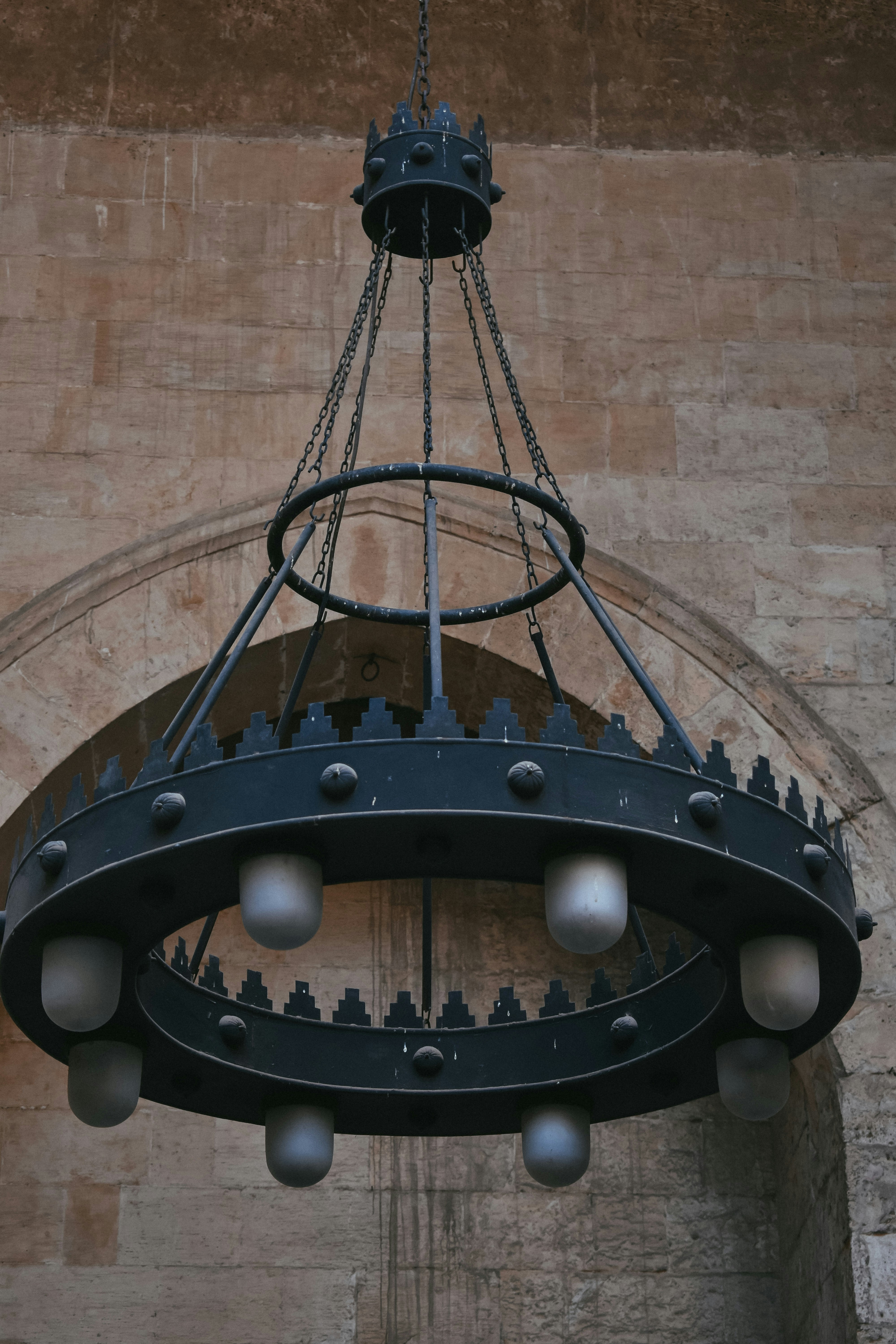 The Hanging Constellation: Iron Rings Gracing a Stone Arch Hall