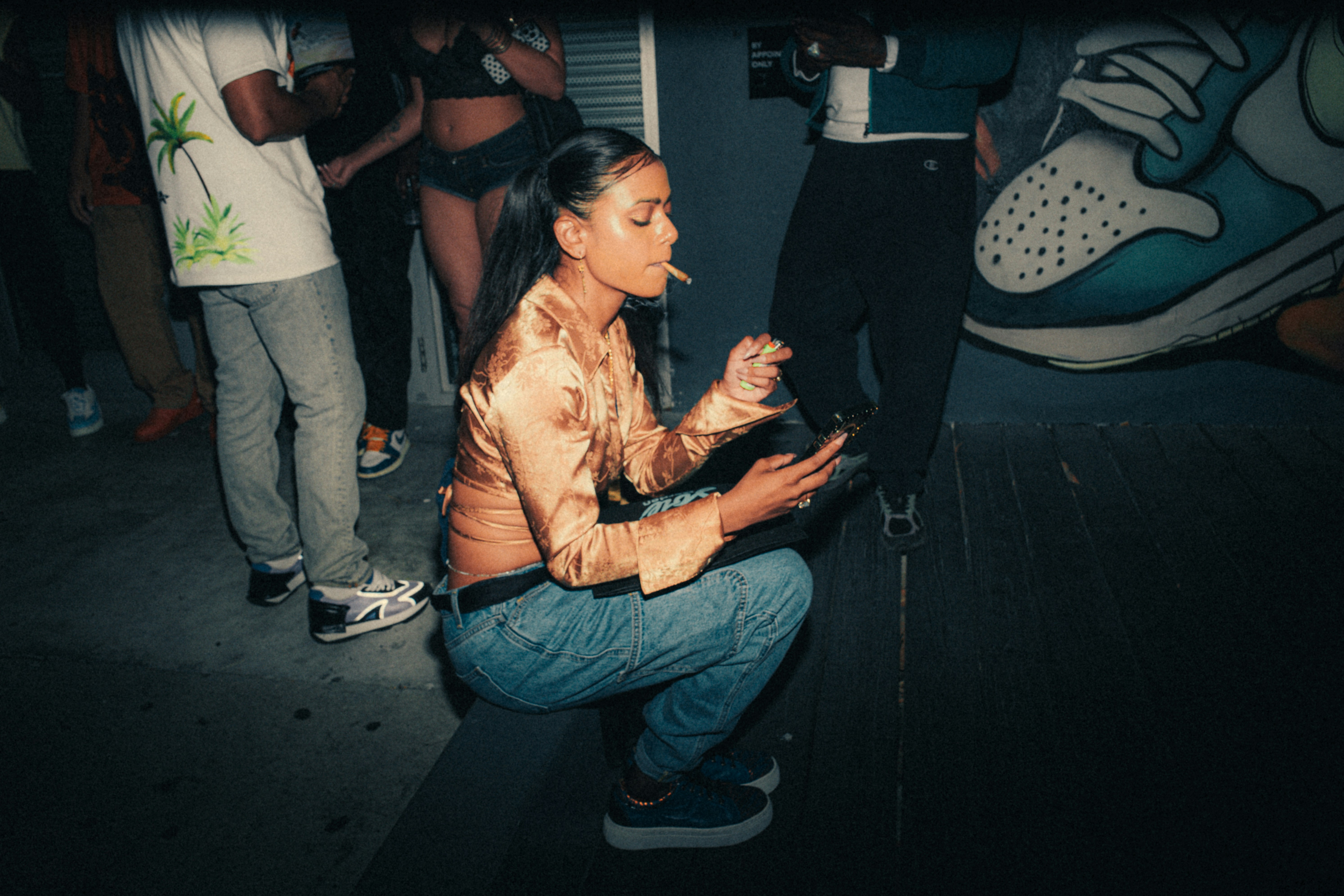 A woman sitting on the ground smoking a cigarette photo – Free Woman ...