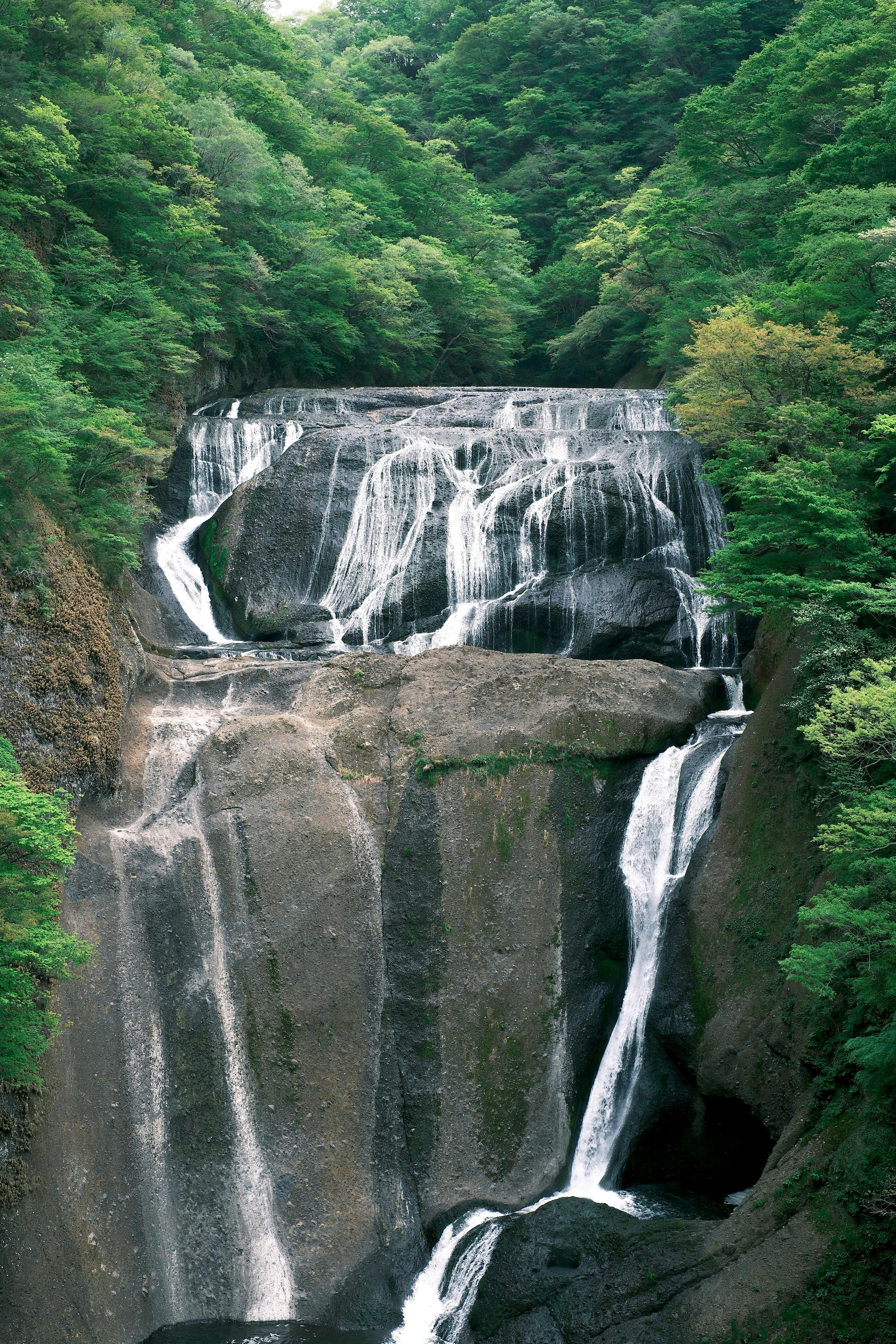 Cascade Crown: A Multilayer Waterfall Surrounded by Green Canopy