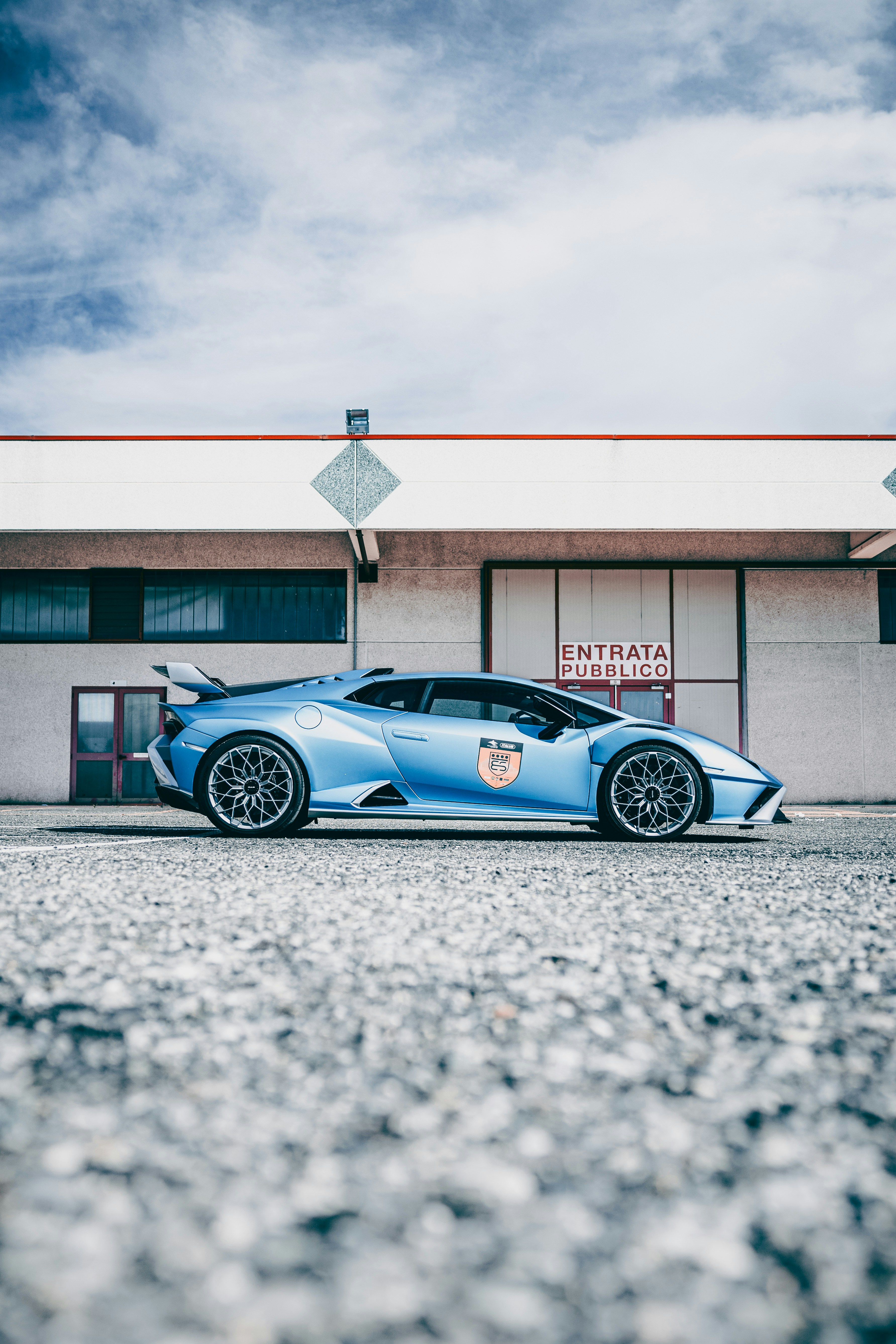 Azure Velocity: A Blue Supercar Anchored in a Quiet Industrial Forecourt