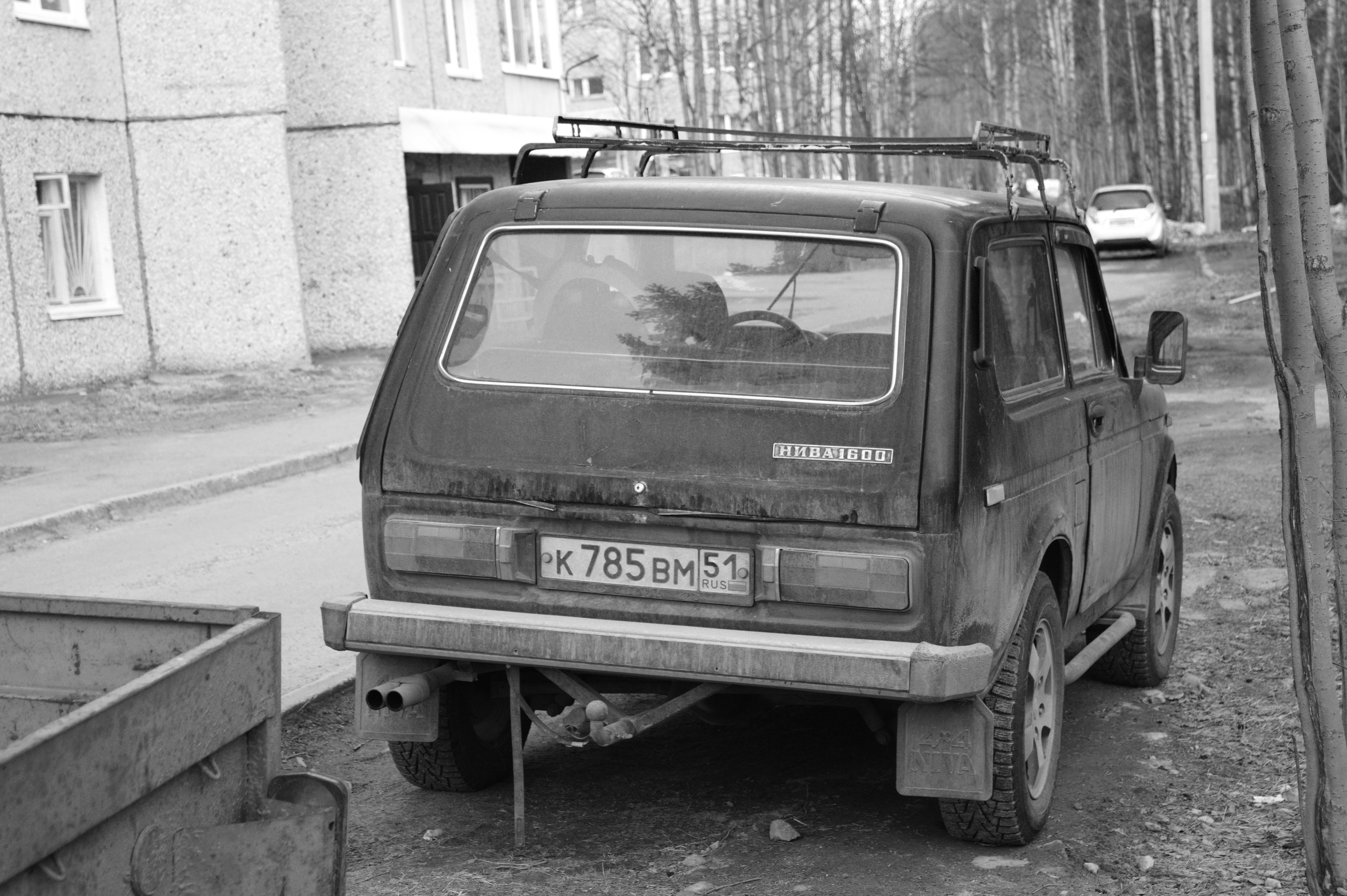 Mud-Streaked Rear View: A Soviet-Era SUV in a Quiet Courtyard