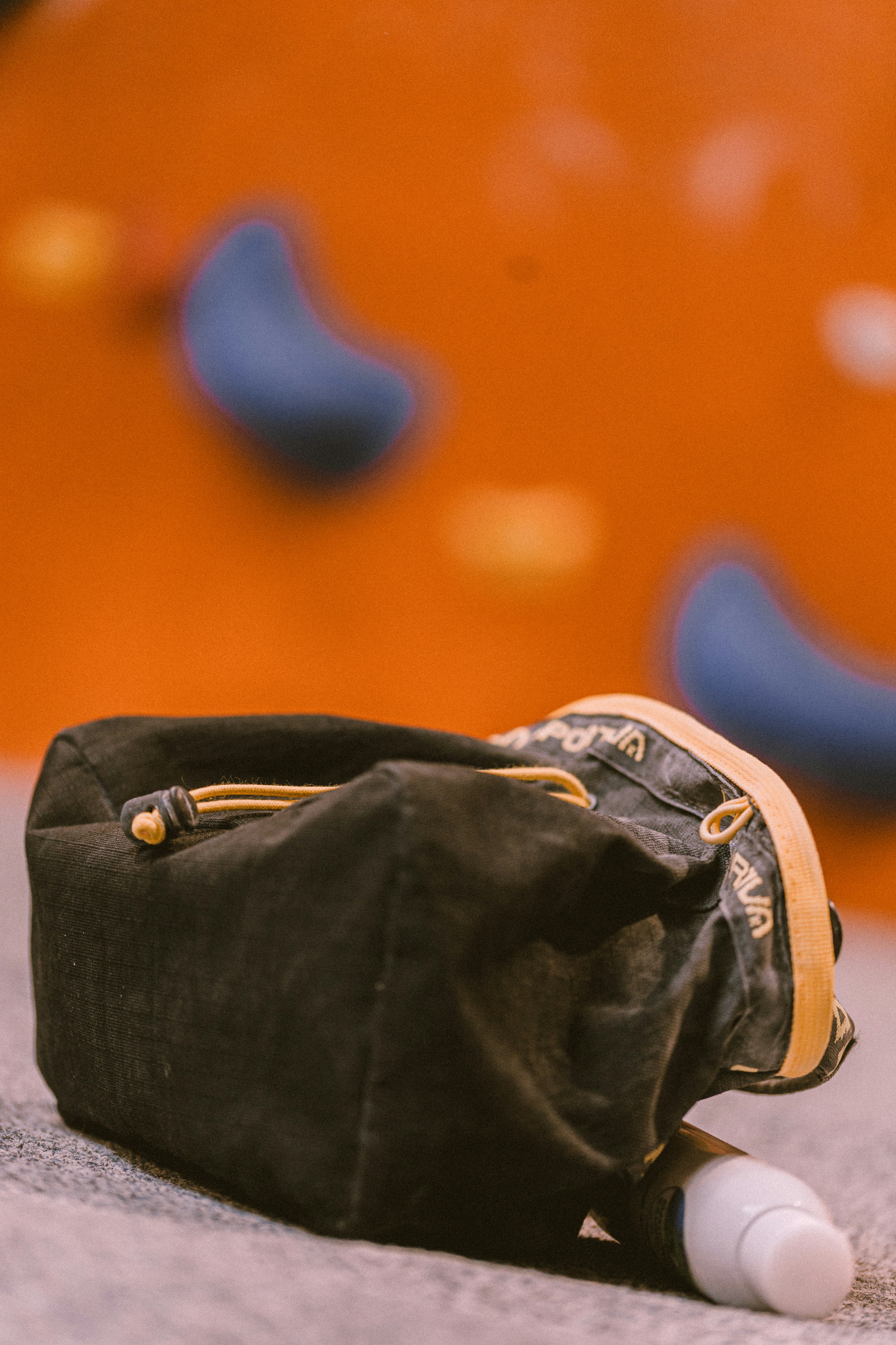 Still Life on the Mat: Black Pouch Under an Orange Gym Wall