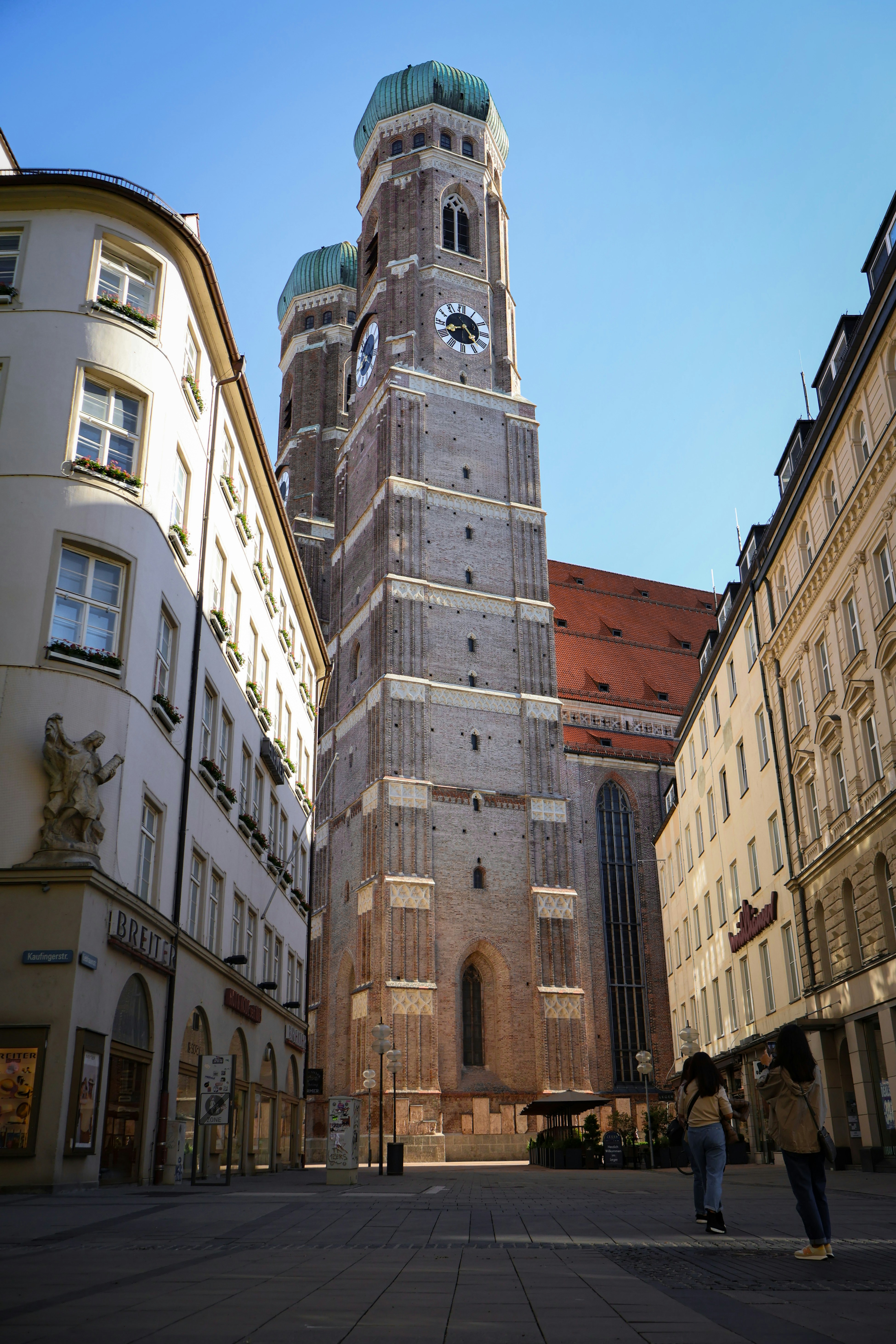 Copper-Domed Clock Tower Rising Between Sunlit European Facades