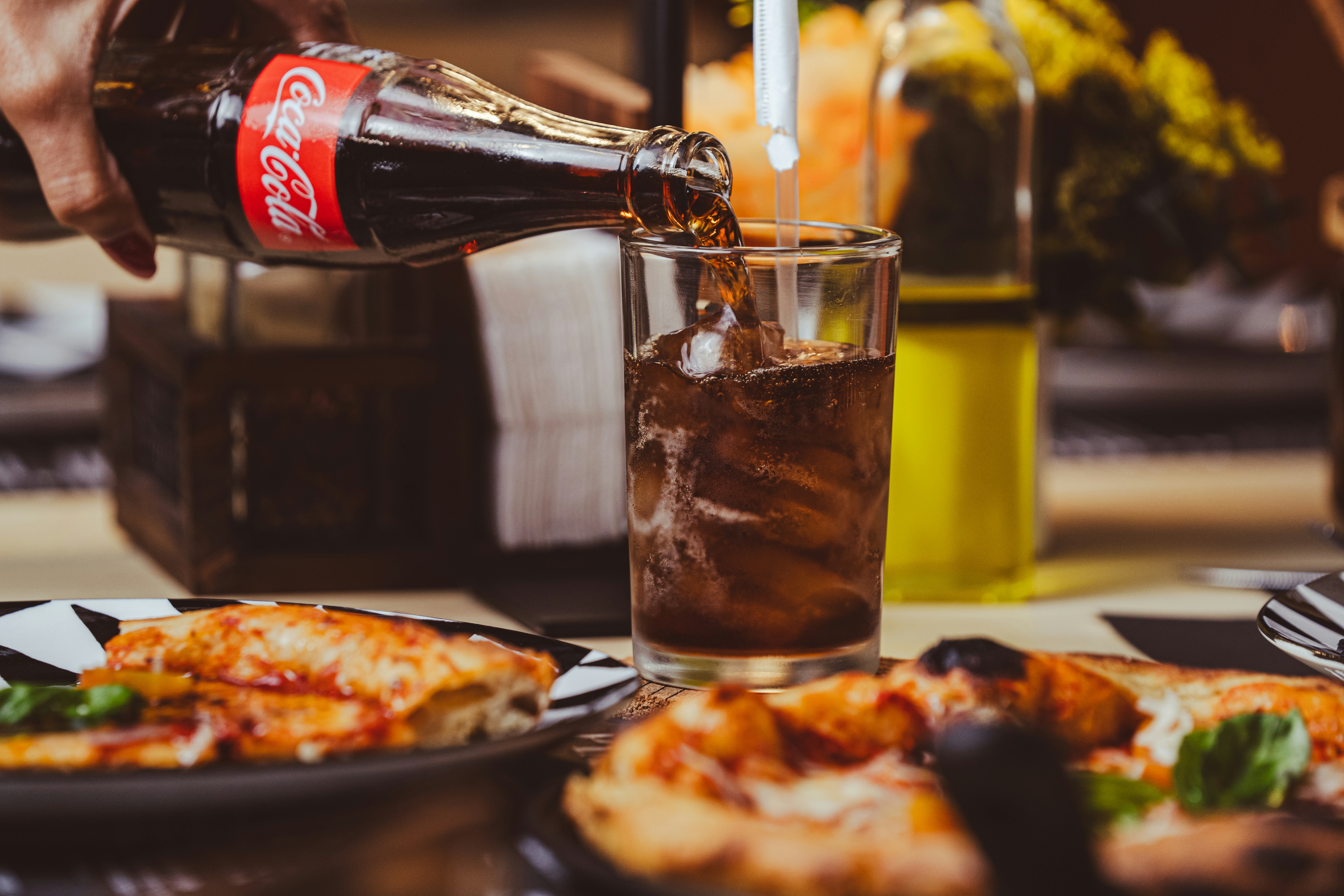 A person pouring coke into a glass of pizza photo – Free Pizza Image on ...