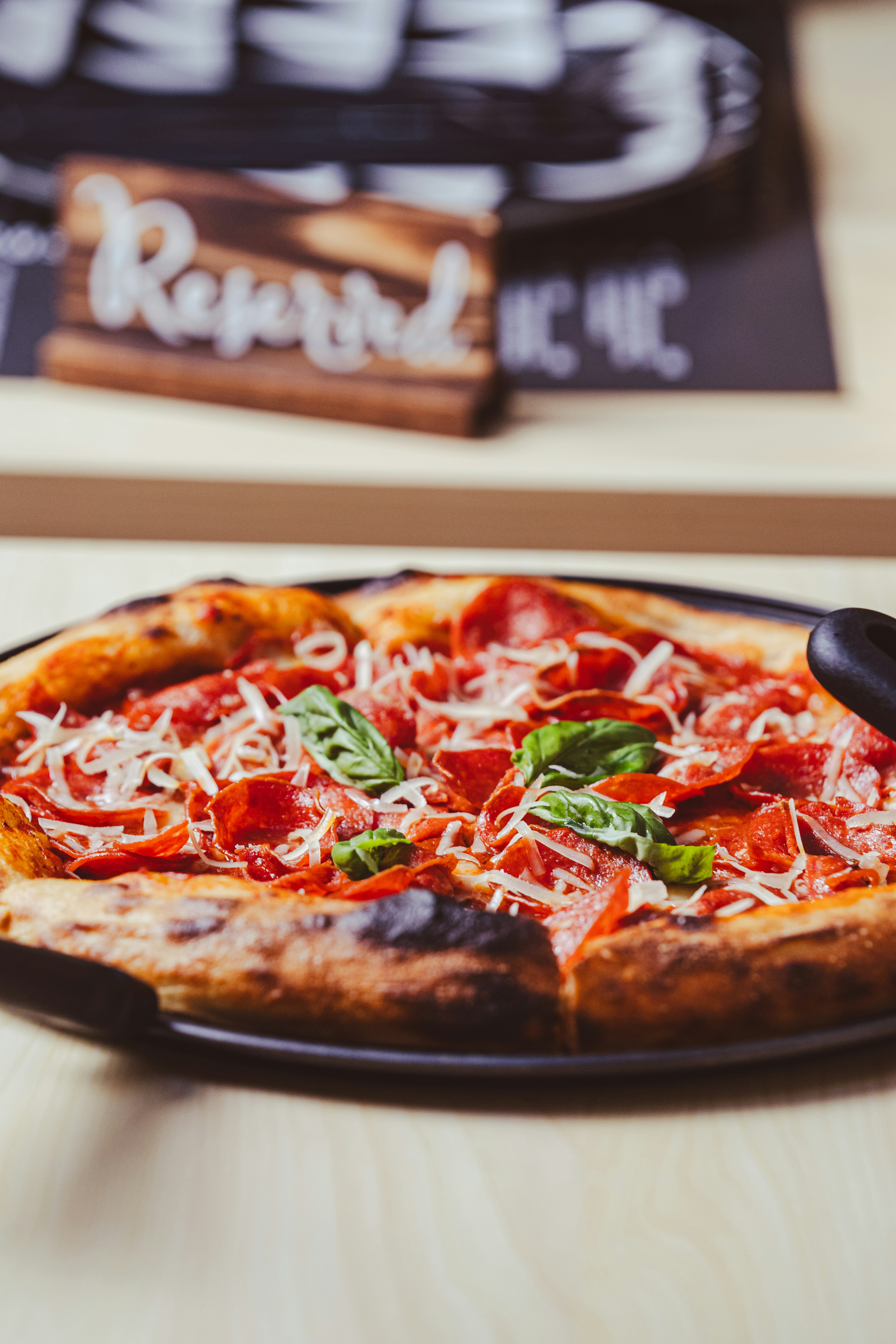 A close up of a pizza on a plate on a table photo – Free Pizza Image on ...