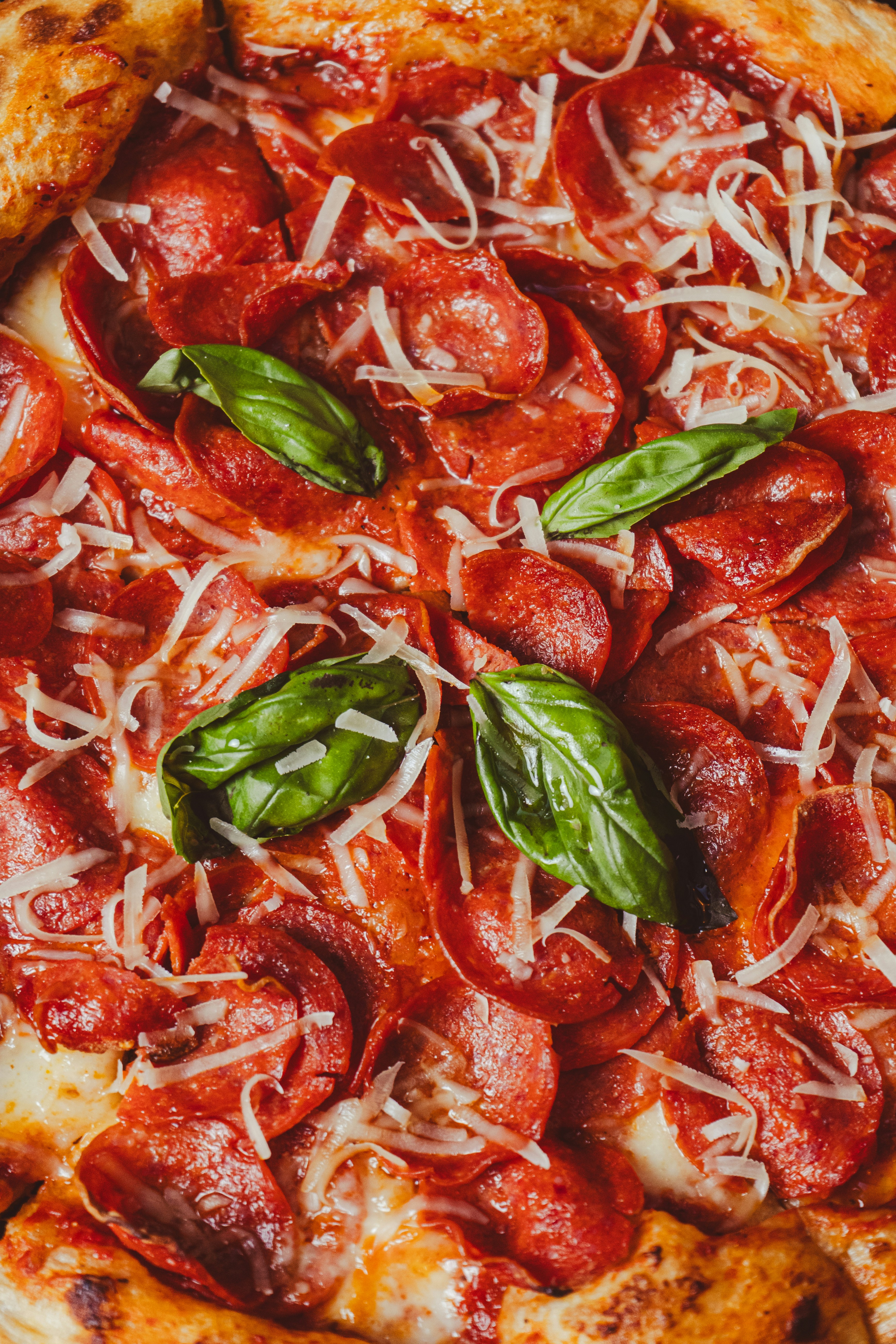 Un primer plano de una pizza de pepperoni con albahaca foto – Imagen de ...