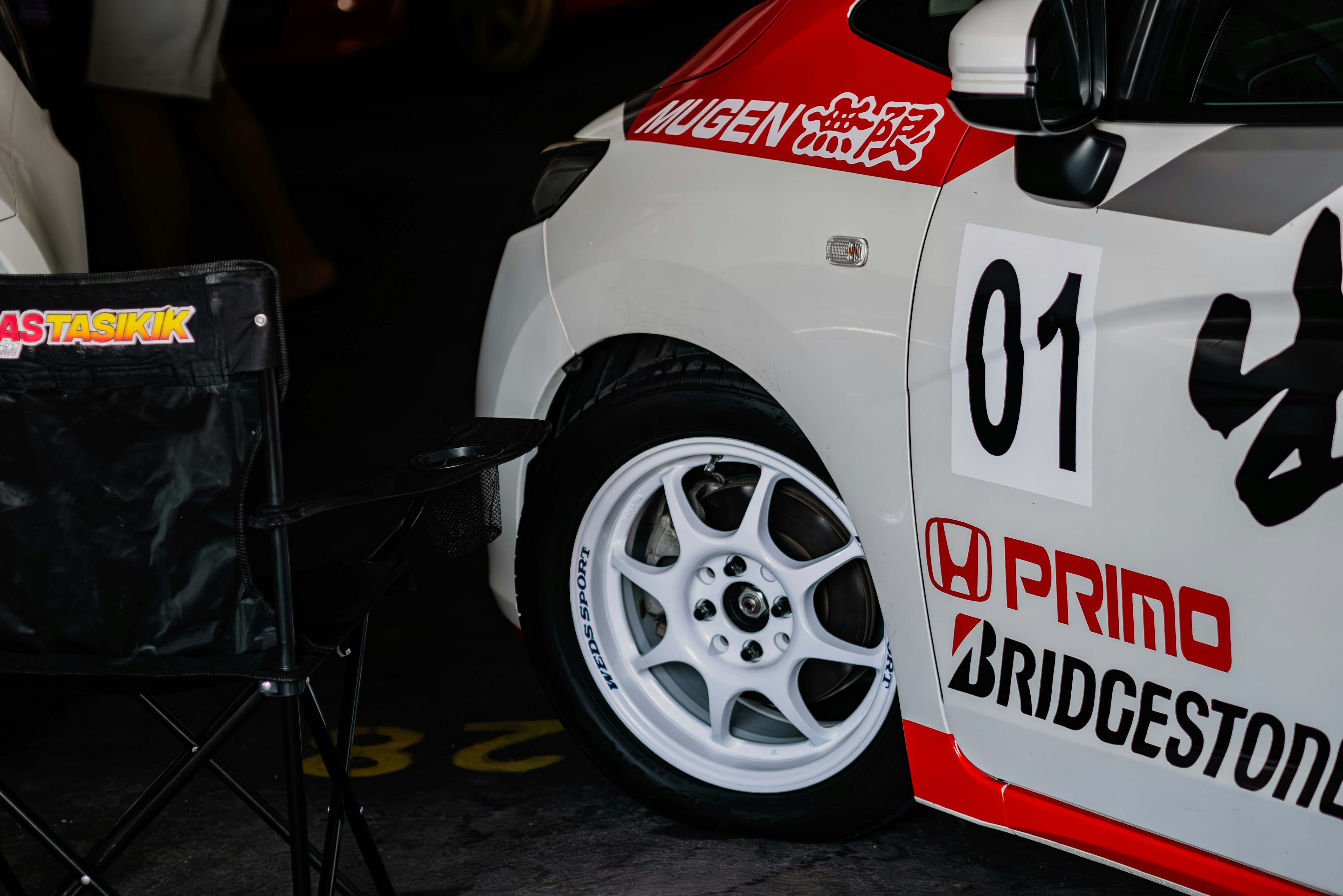01 in the Pits: a white race car with Bridgestone and Primo branding around a gleaming wheel
