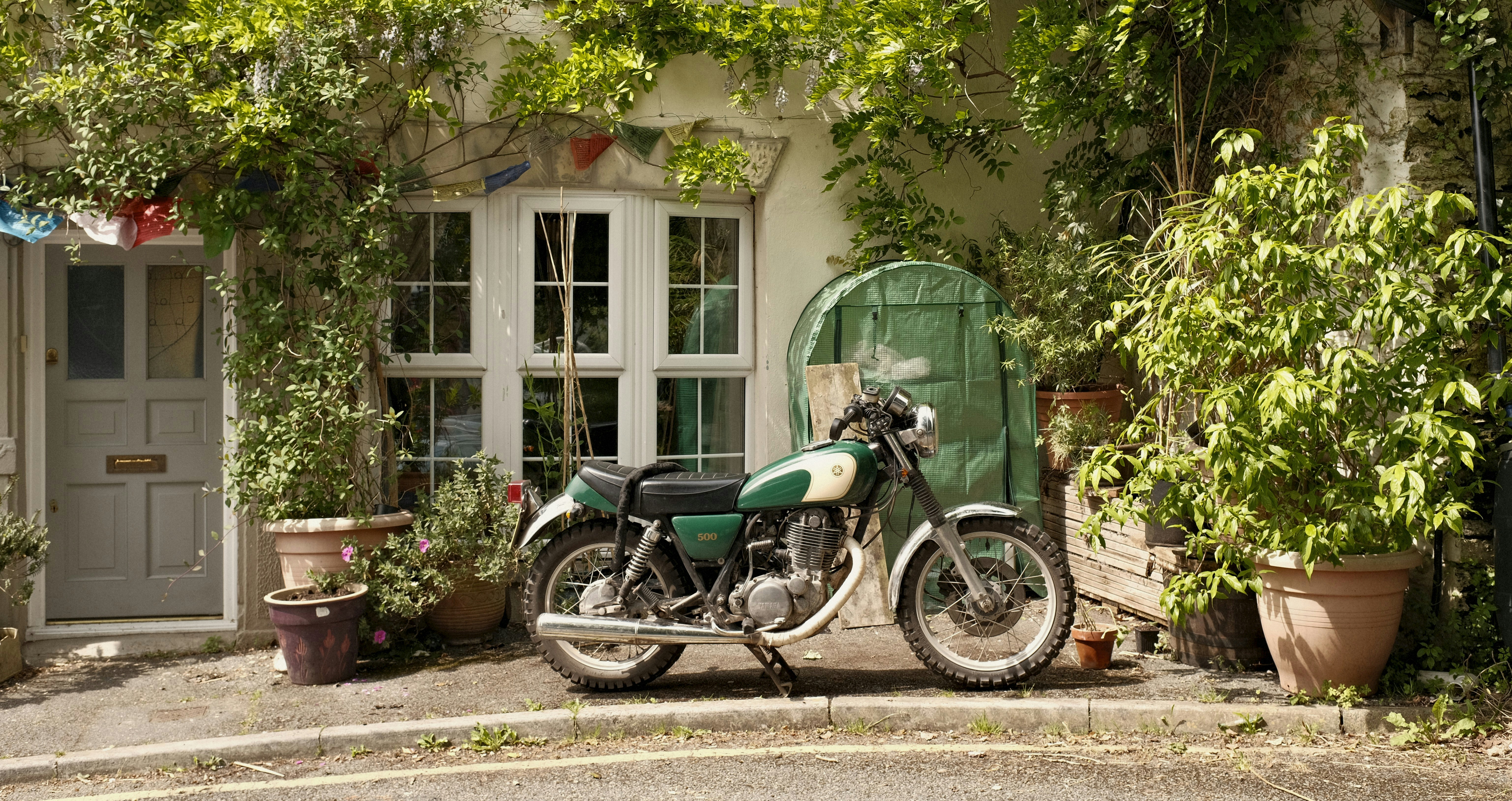 Green Vintage Ride Resting by a Mossy Courtyard