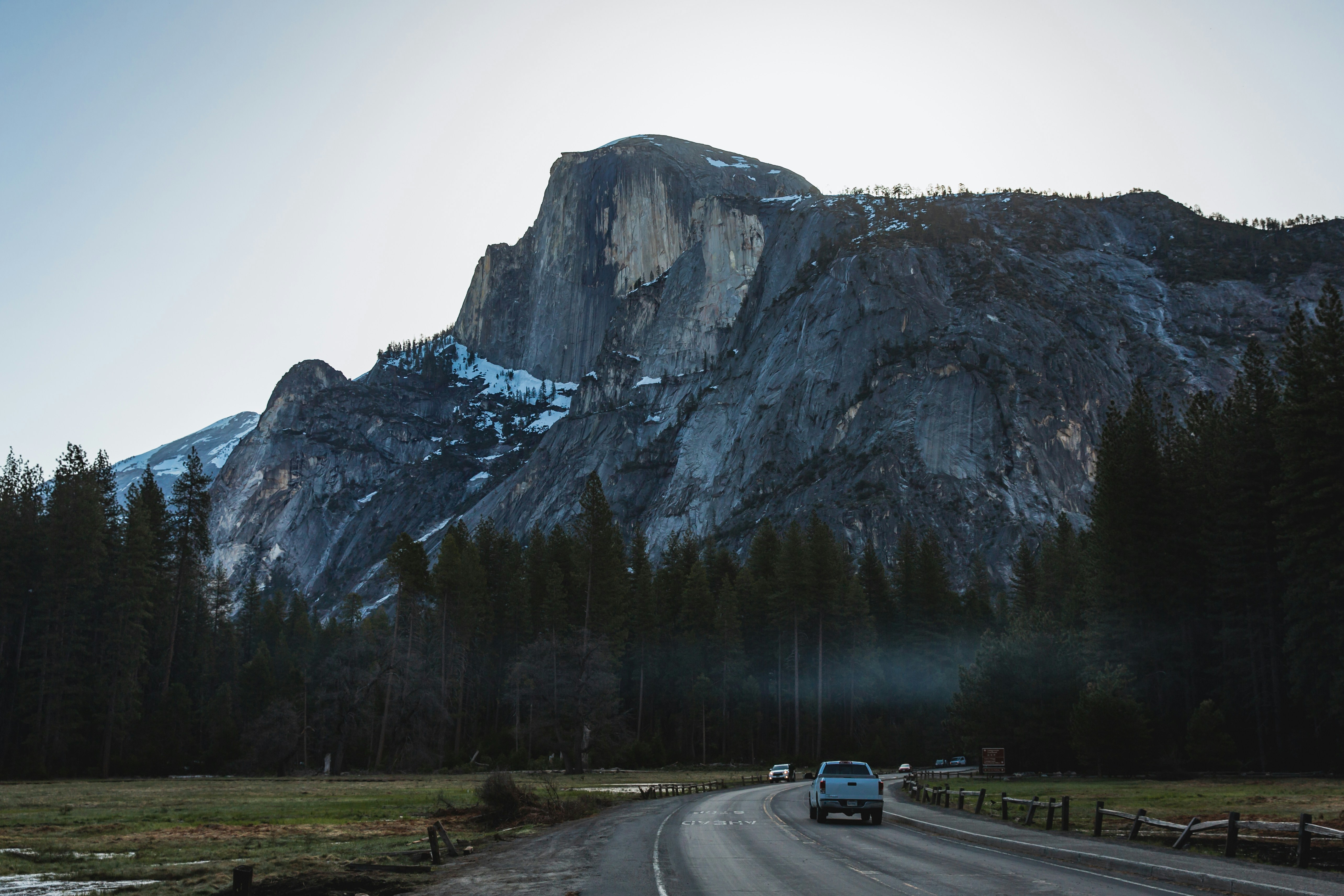 Snowbound Peak Looms Over a Quiet Valley Road at Dusk