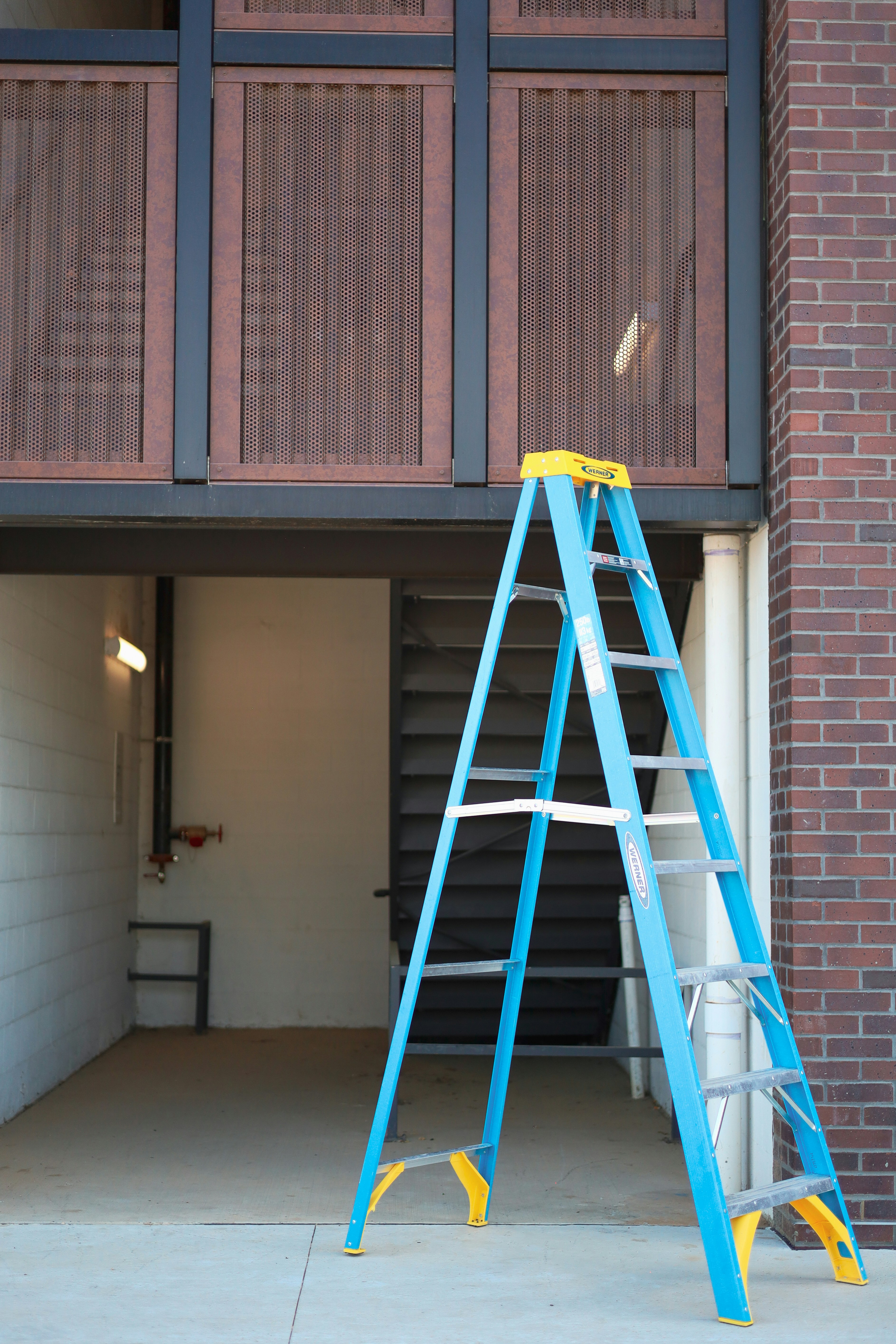 A blue ladder leaning against a brick building photo – Free Nc Image on ...