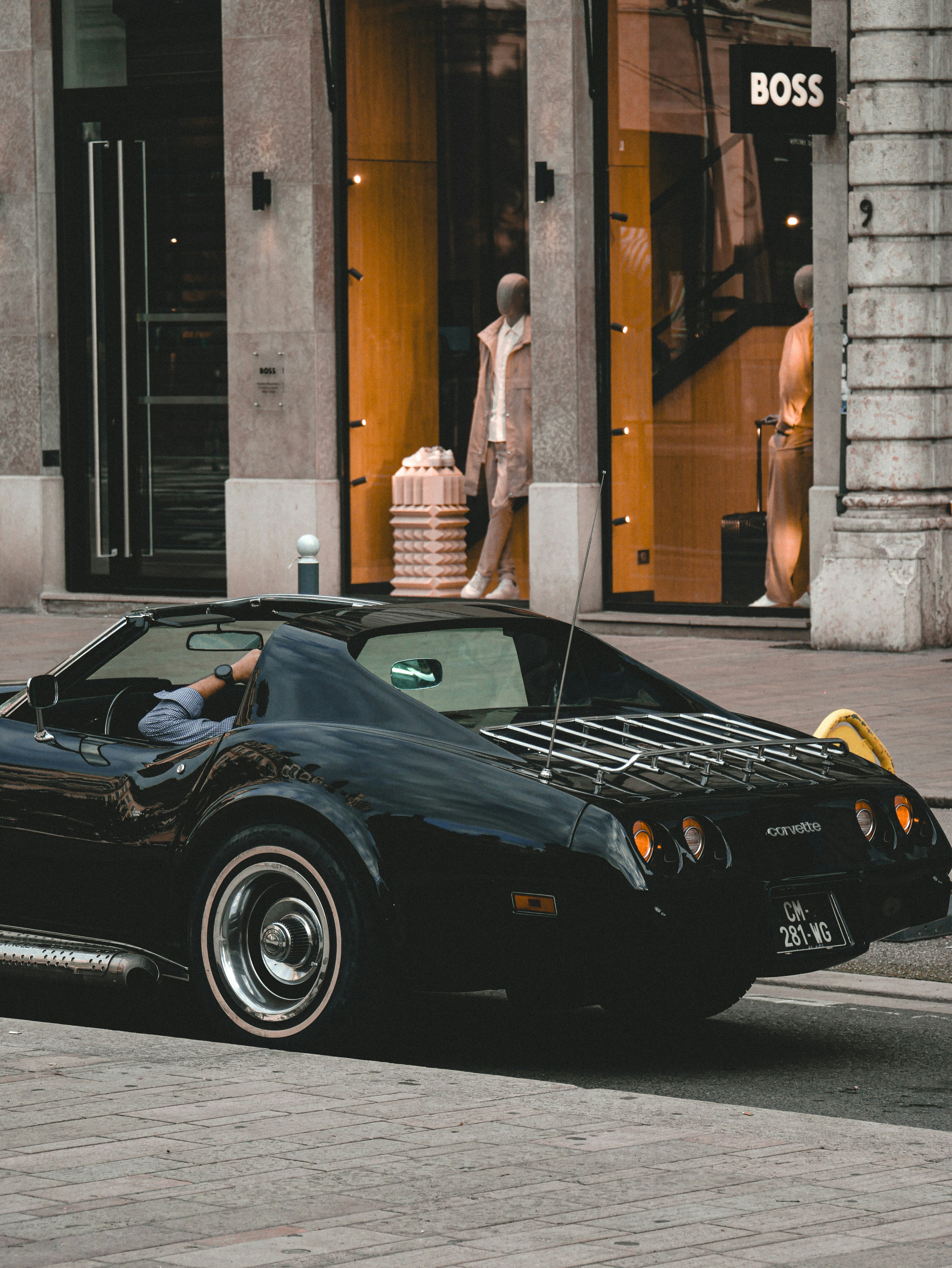 Chrome and Couture: A Black Corvette at the Fashion District storefront