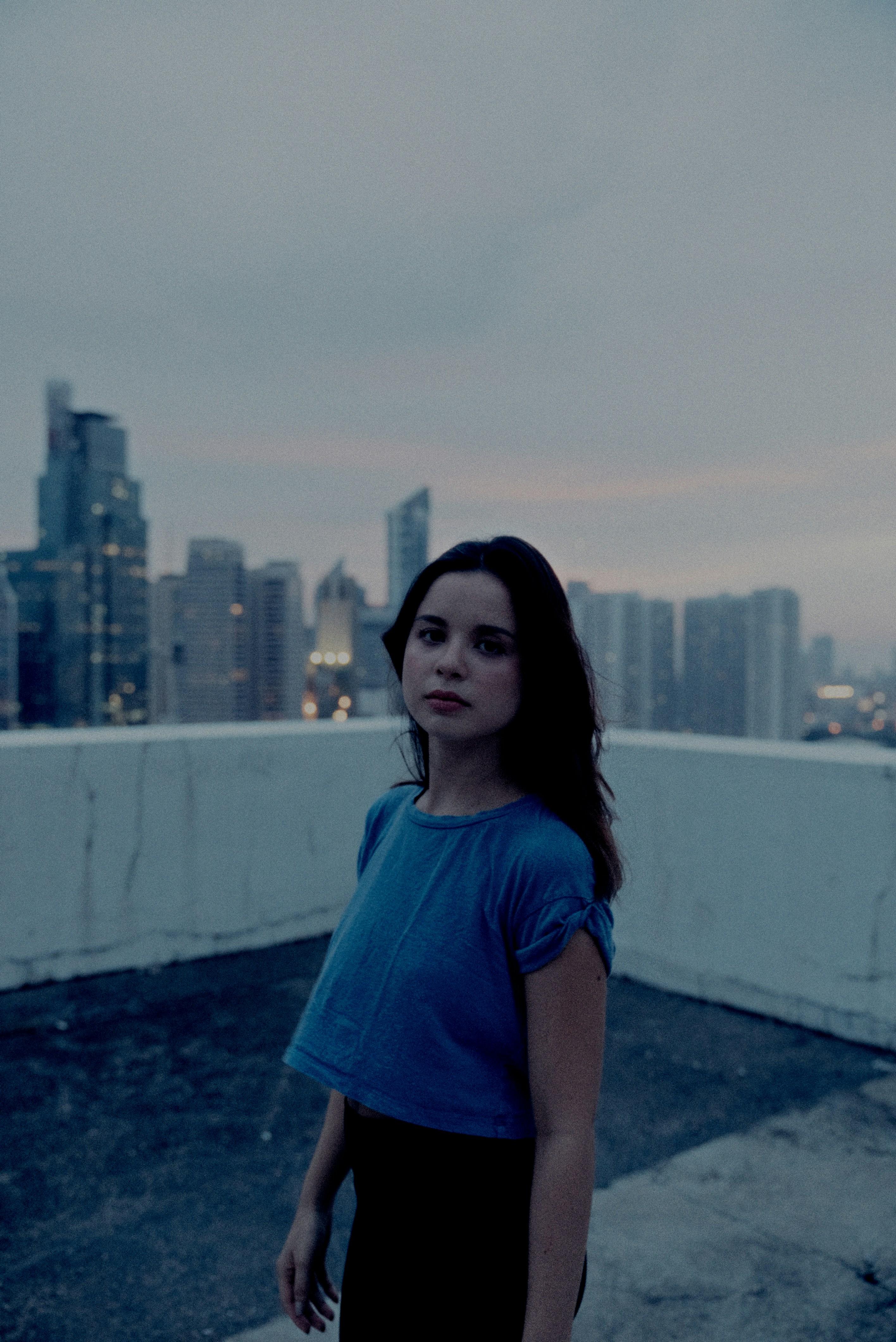 Blue Hour Rooftop Portrait Against a Distant Cityscape