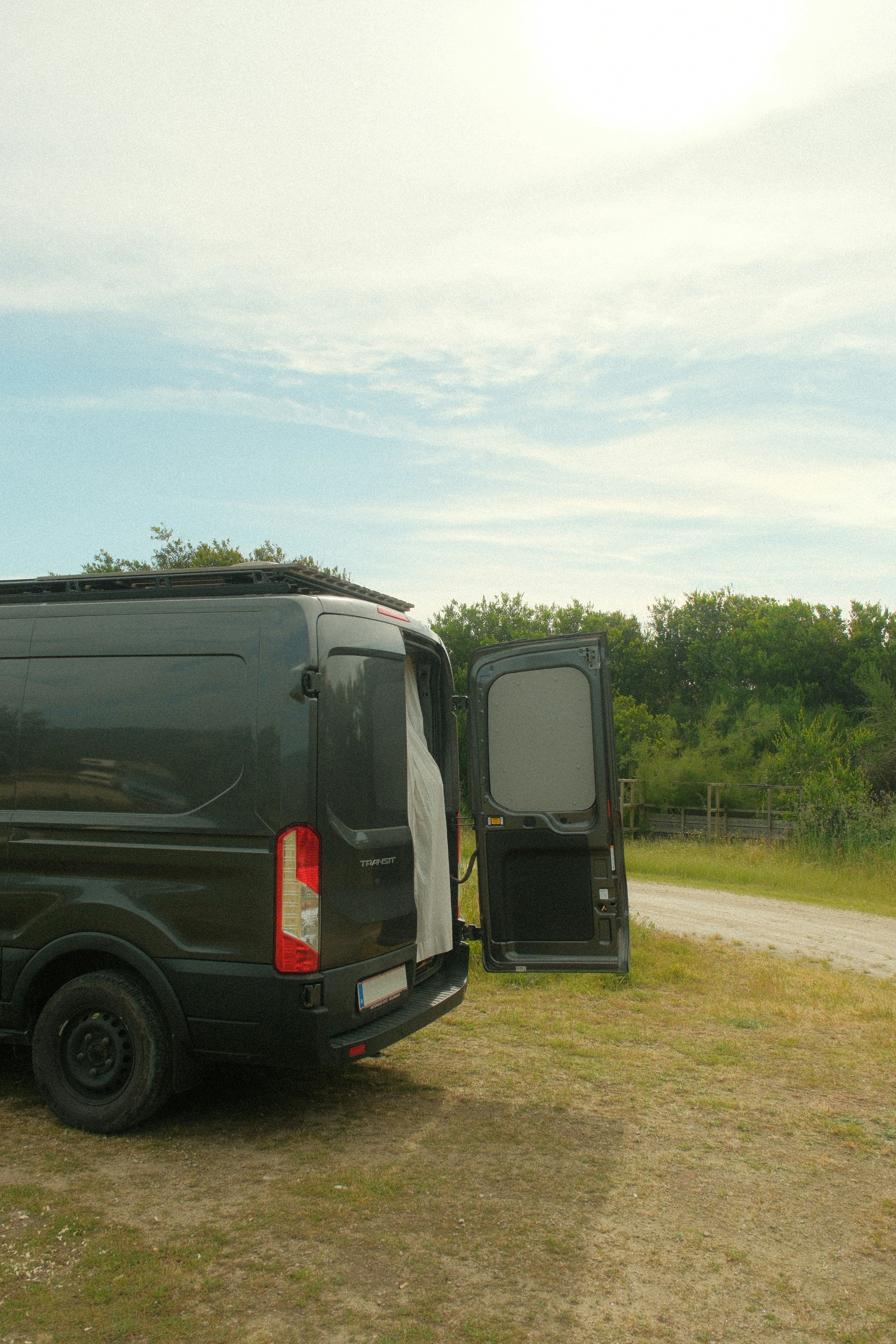Open-Back Adventuring: A Dark Camper Van at the Edge of a Quiet Clearing