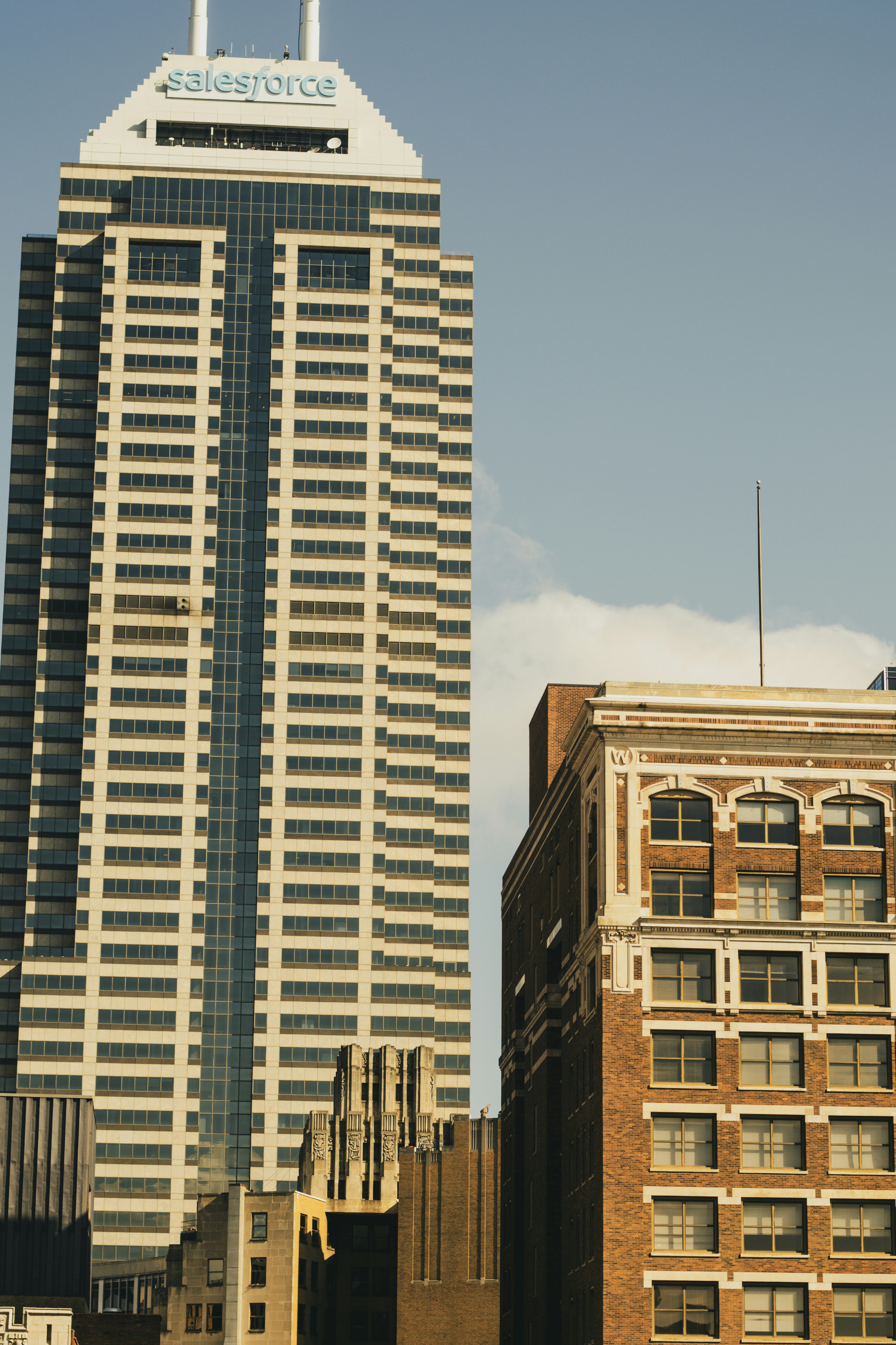 A tall building with a sky scraper in the background photo – Free ...