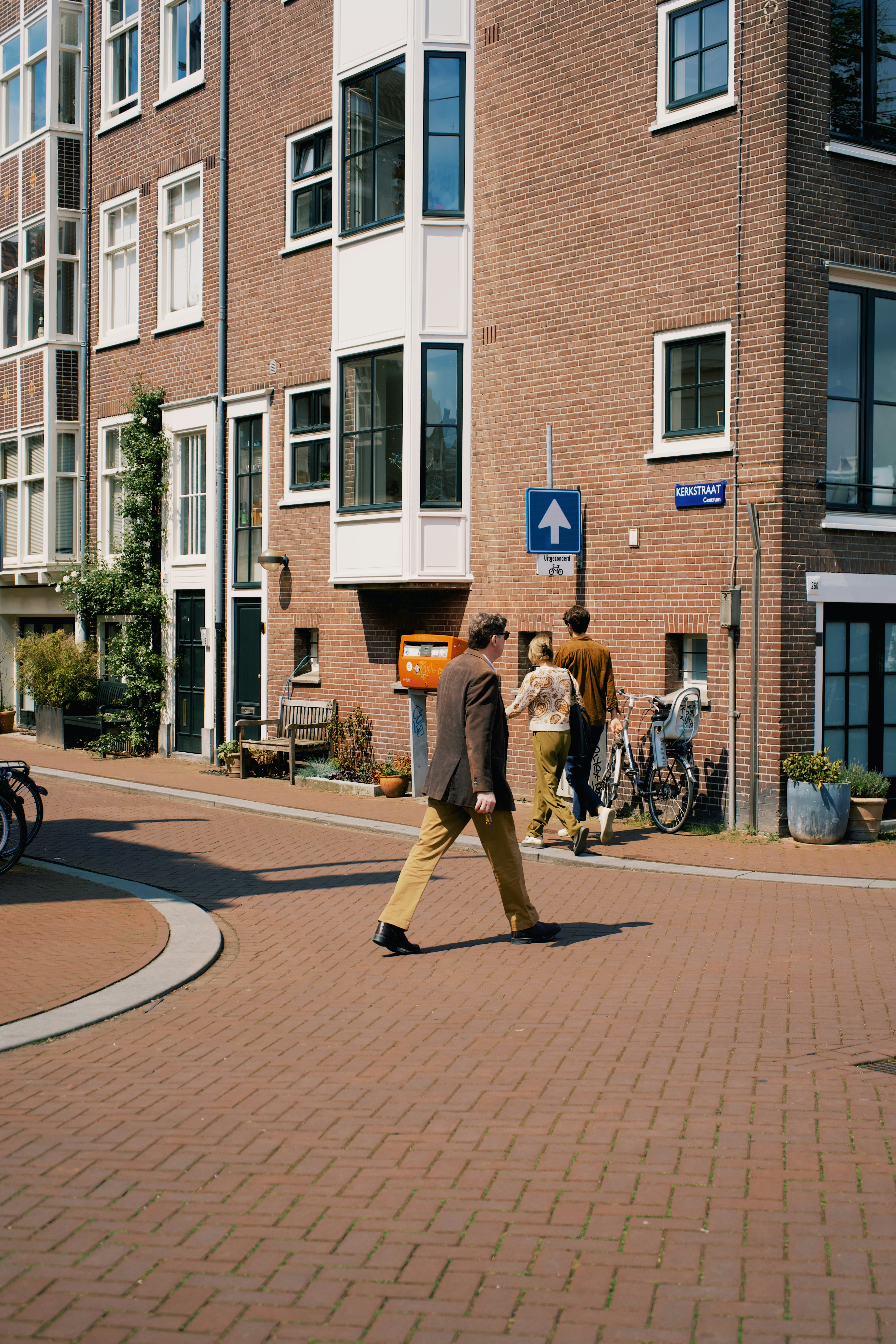 Brick-Street Stroll Across a Sunlit Urban Block