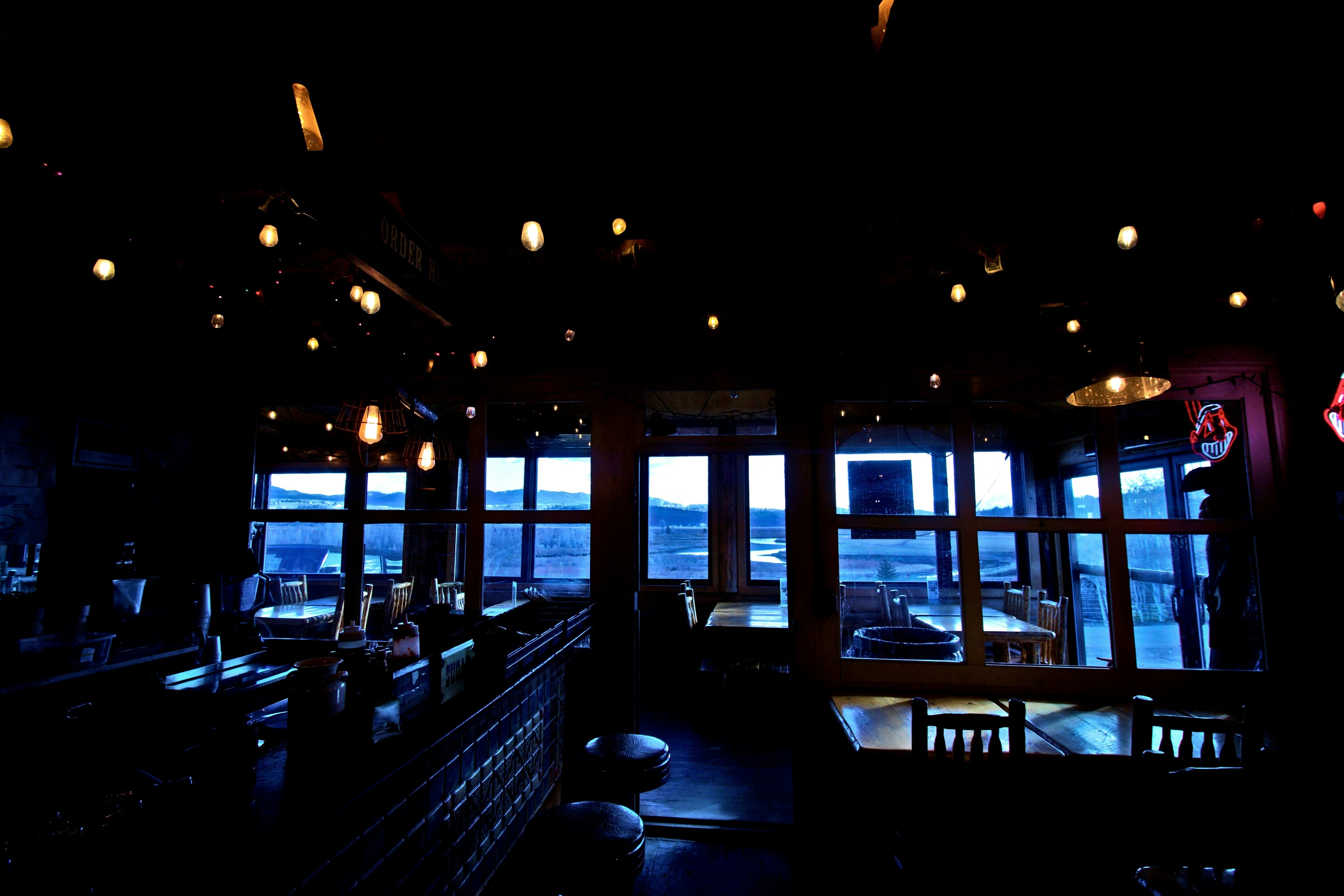 A dimly lit restaurant with a view of the ocean photo – Free Moran ...