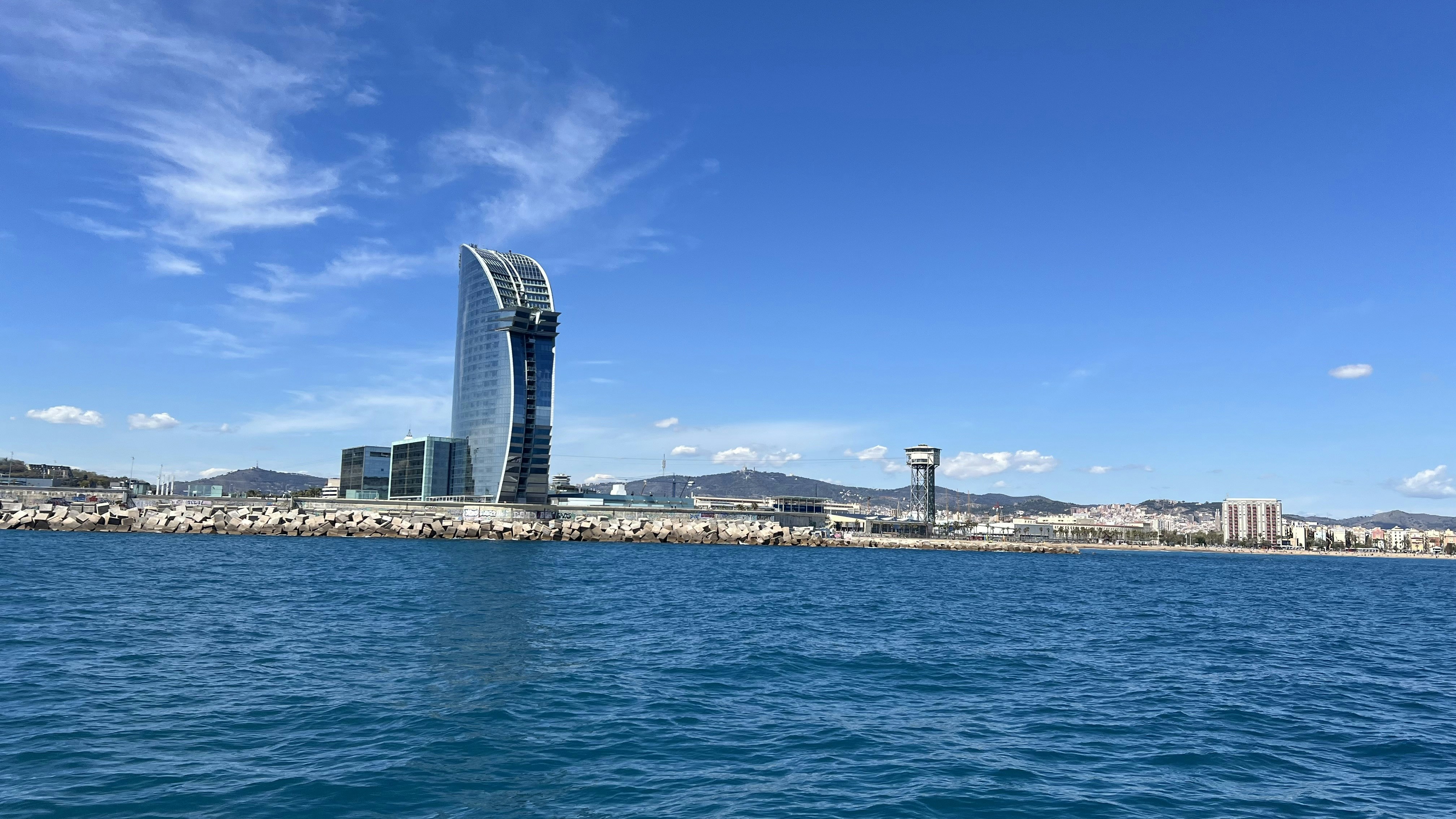 Glass-Arc Tower Framing a Calm Seafront Horizon