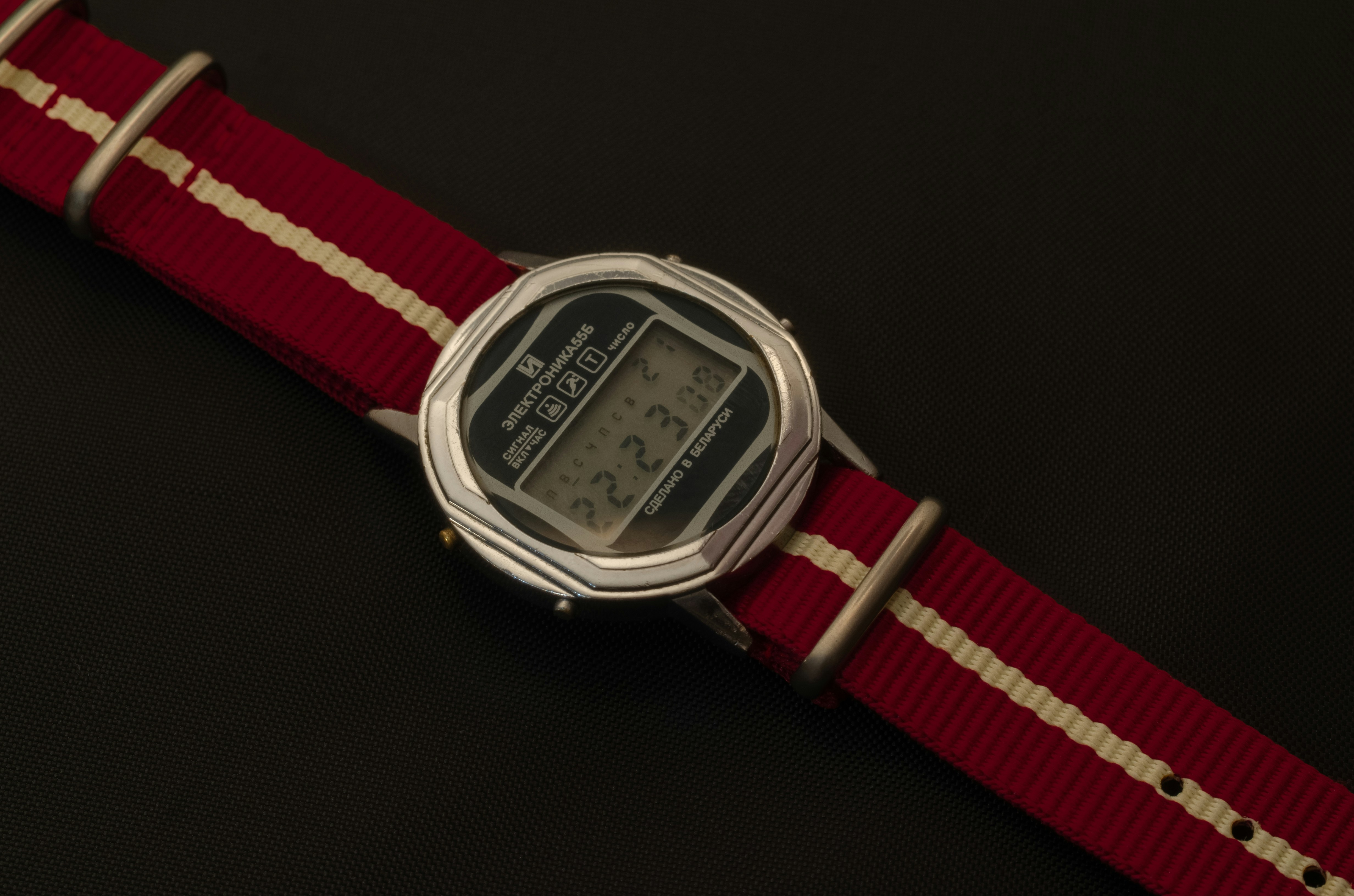 Crimson Strap, Quiet Pulse: Close-Up of a Retro Digital Watch on a Noir Surface
