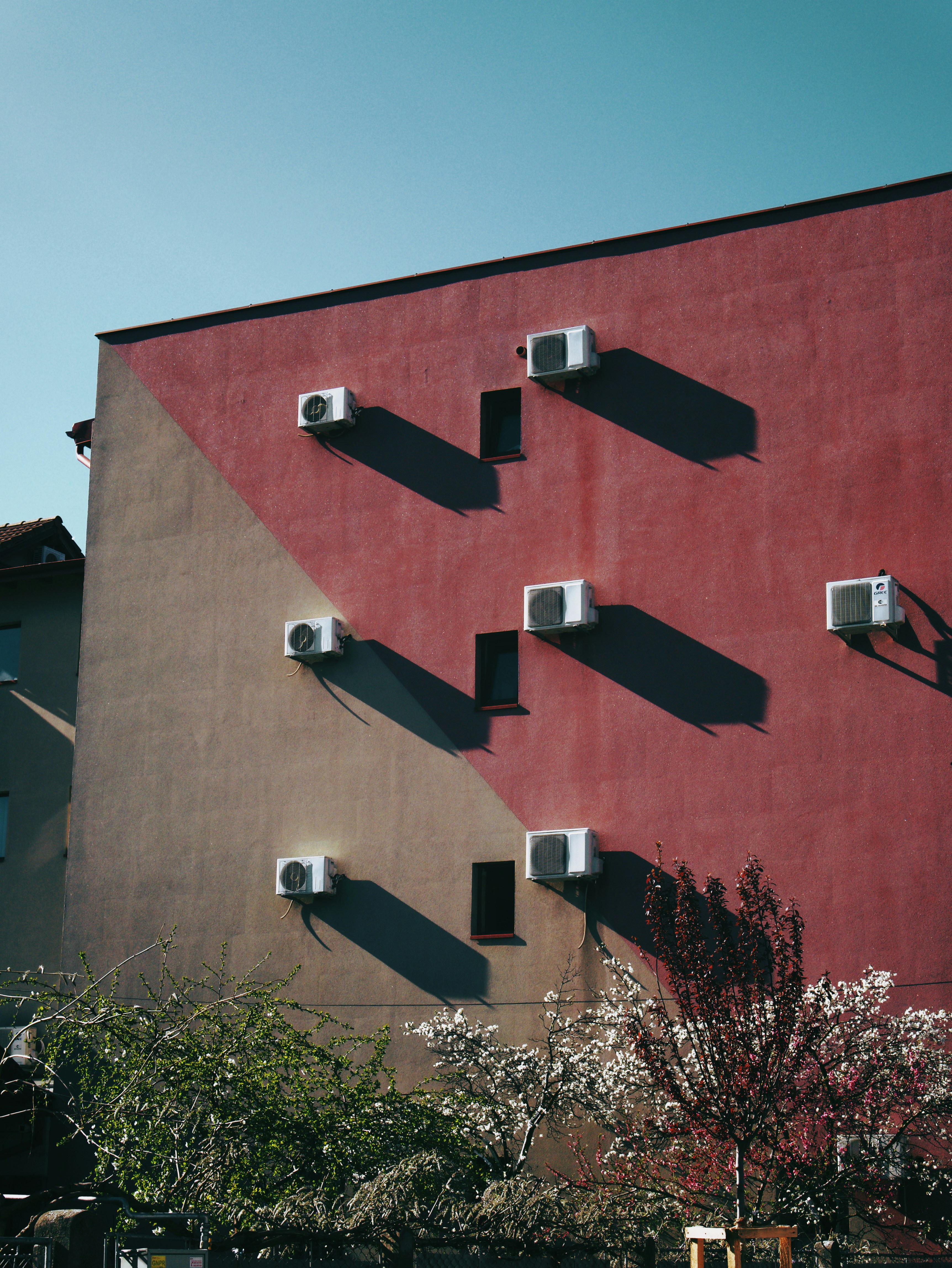 A red building with air conditioners on the side of it photo – Free ...