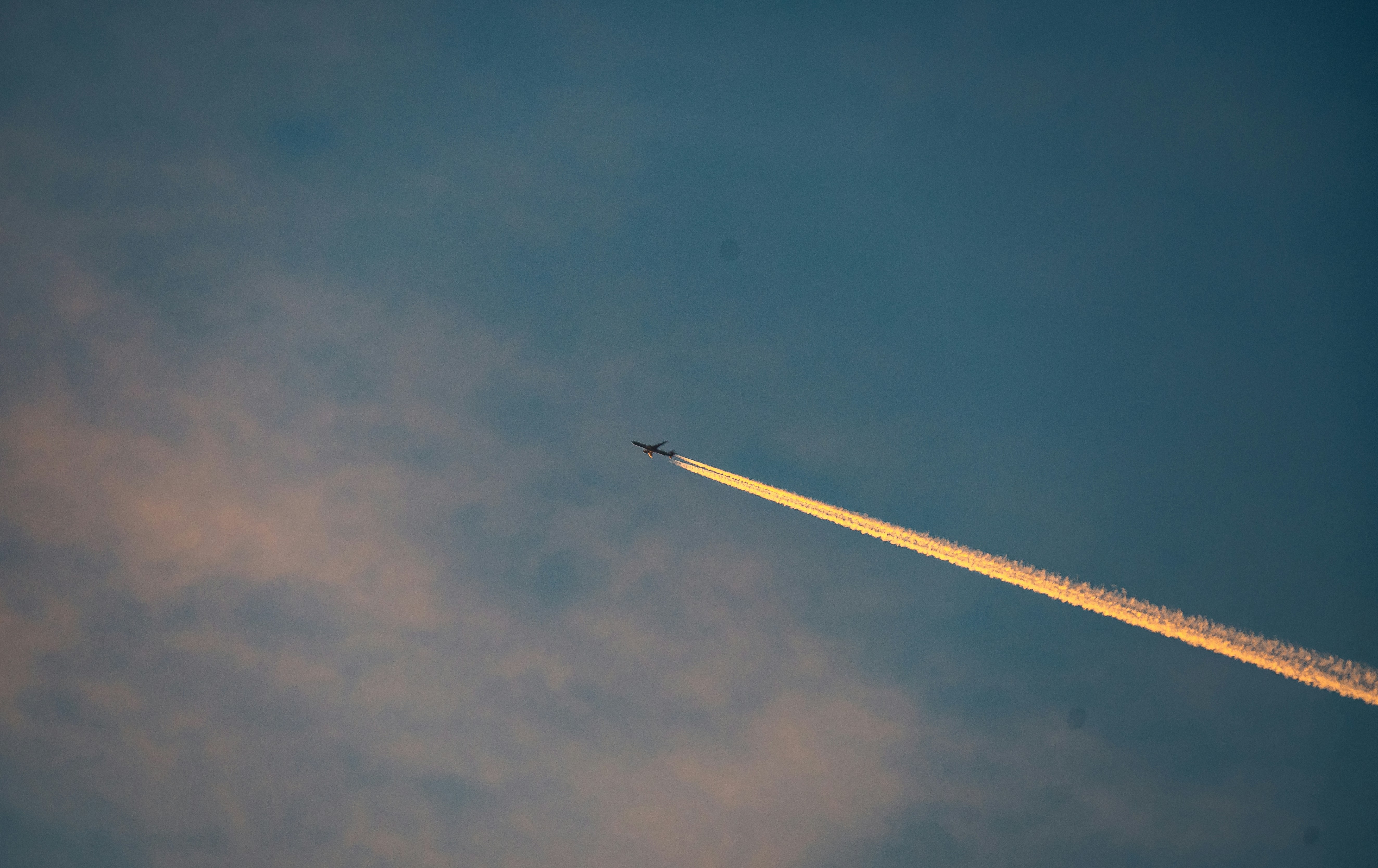 A jet flying through a cloudy blue sky photo – Free China Image on Unsplash