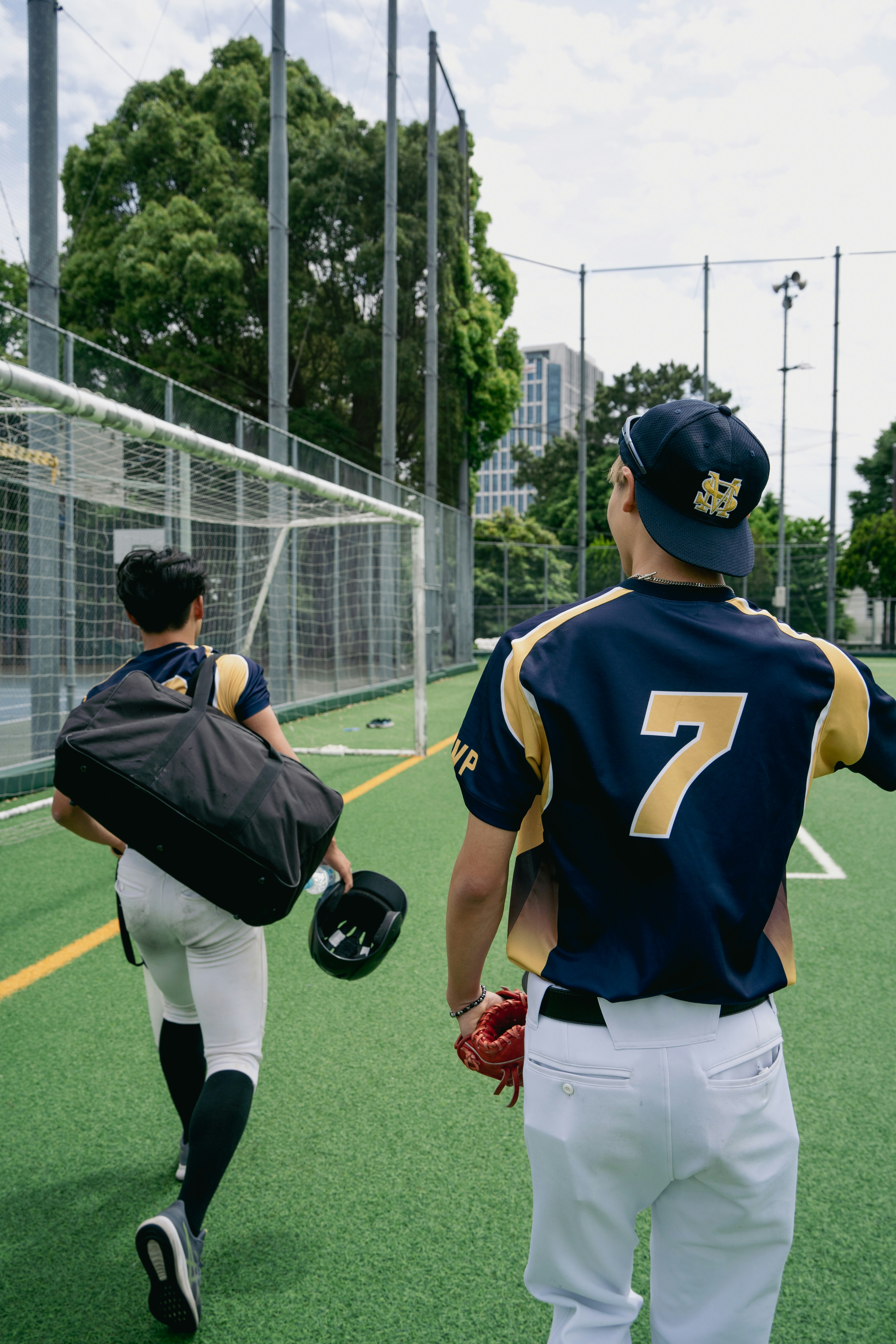 Chasing the Shot: Two Players Walk Off Field at Dusk