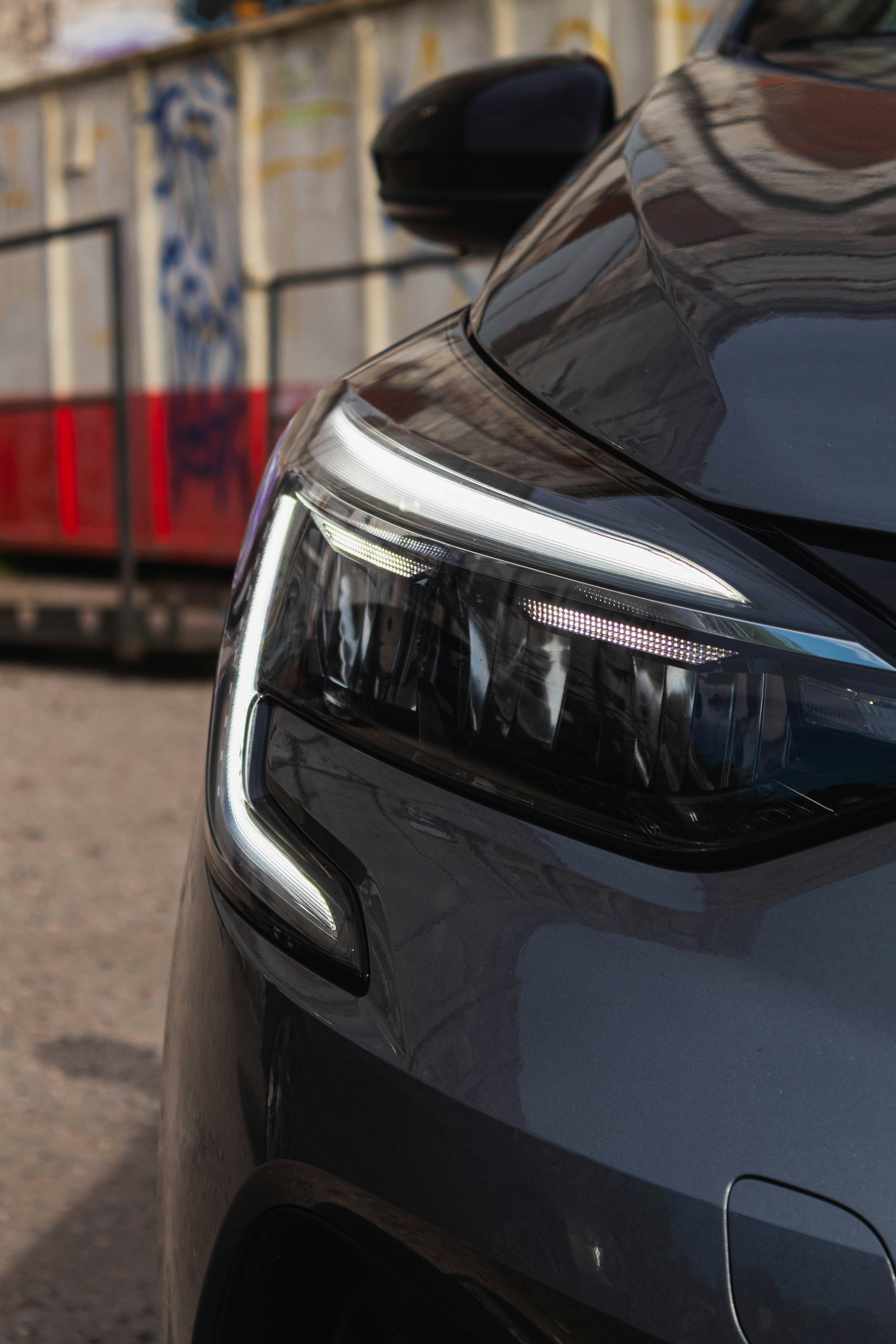 Close-Up of a Modern Headlight Grille: Sculpted Car Front with Reflections
