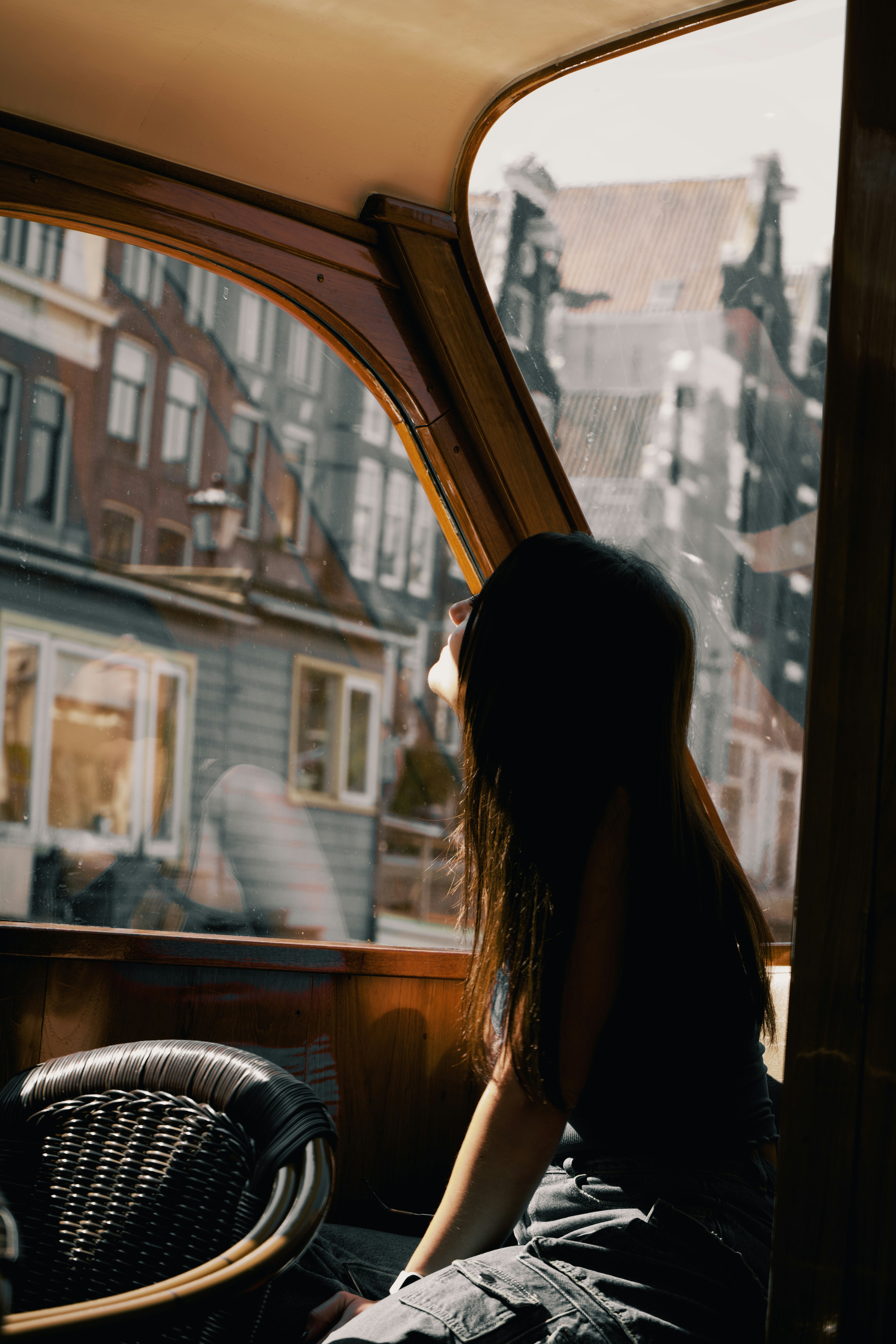 Curved-Cabin Portrait: A Quiet Moment with a City in View