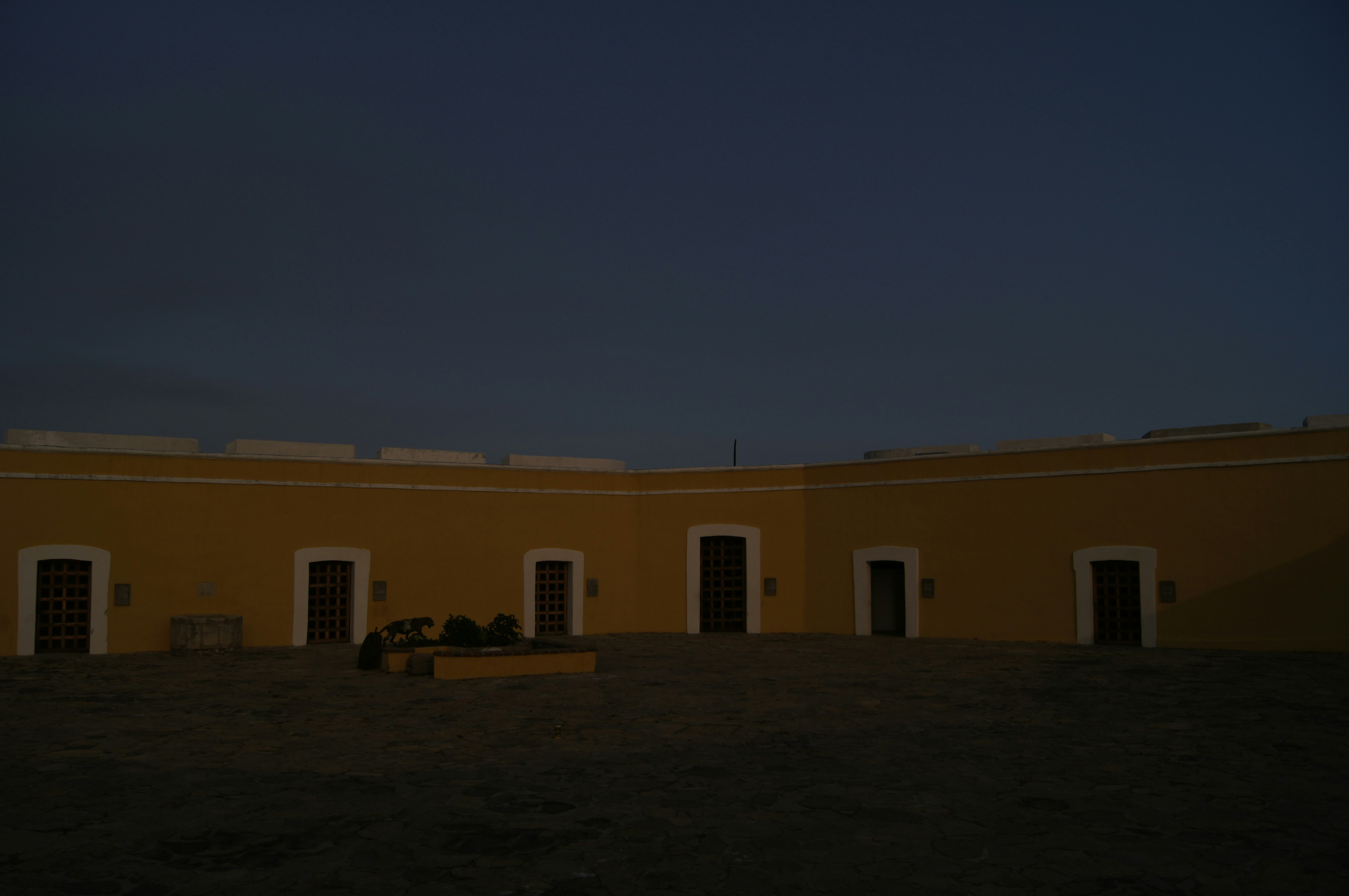 Moonlit Yellow Facade: A Quiet Row of Arched Doors