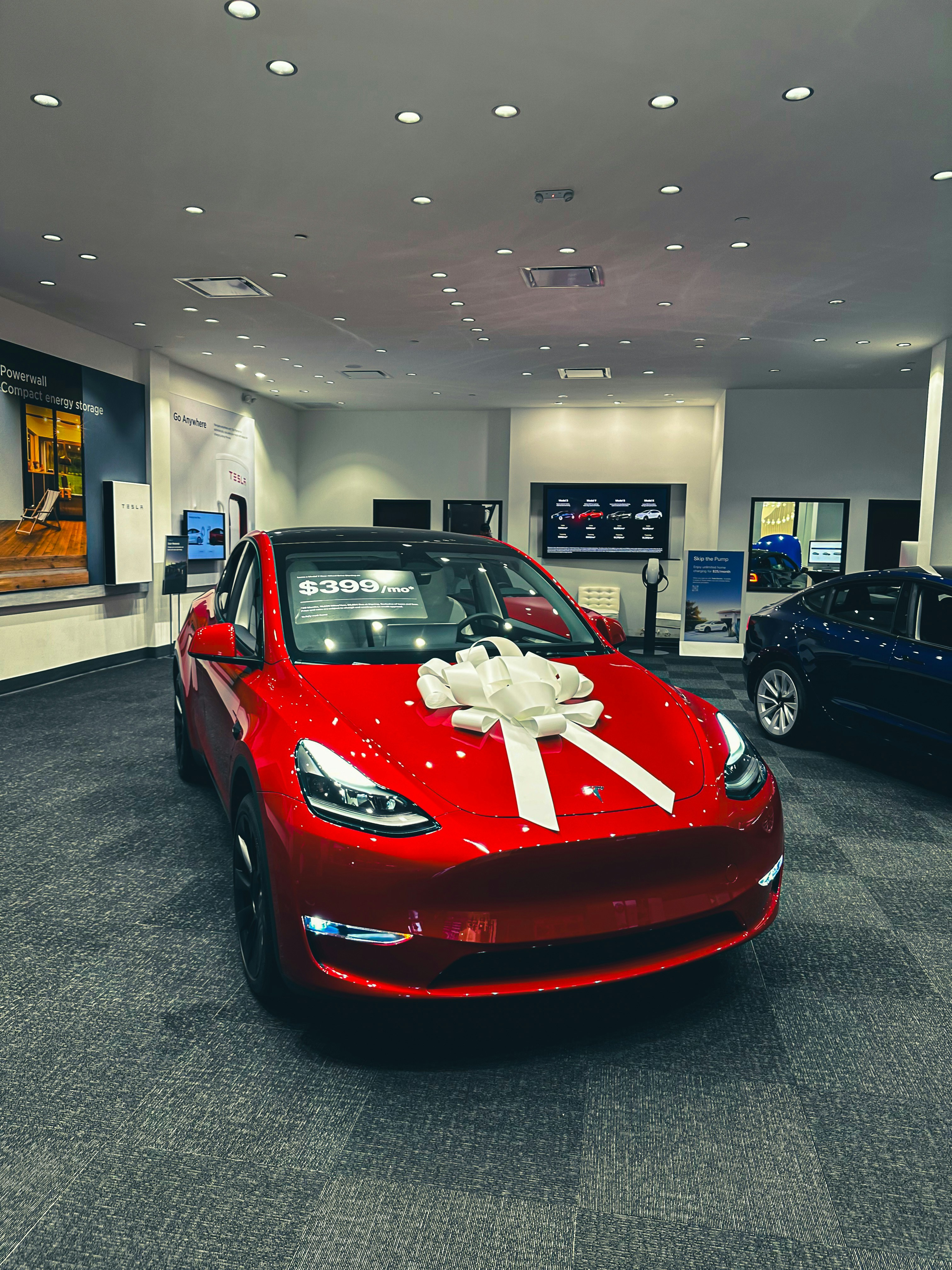 Gift-Wrapped Center Stage: A Red Electric Sedan Graces the Showroom