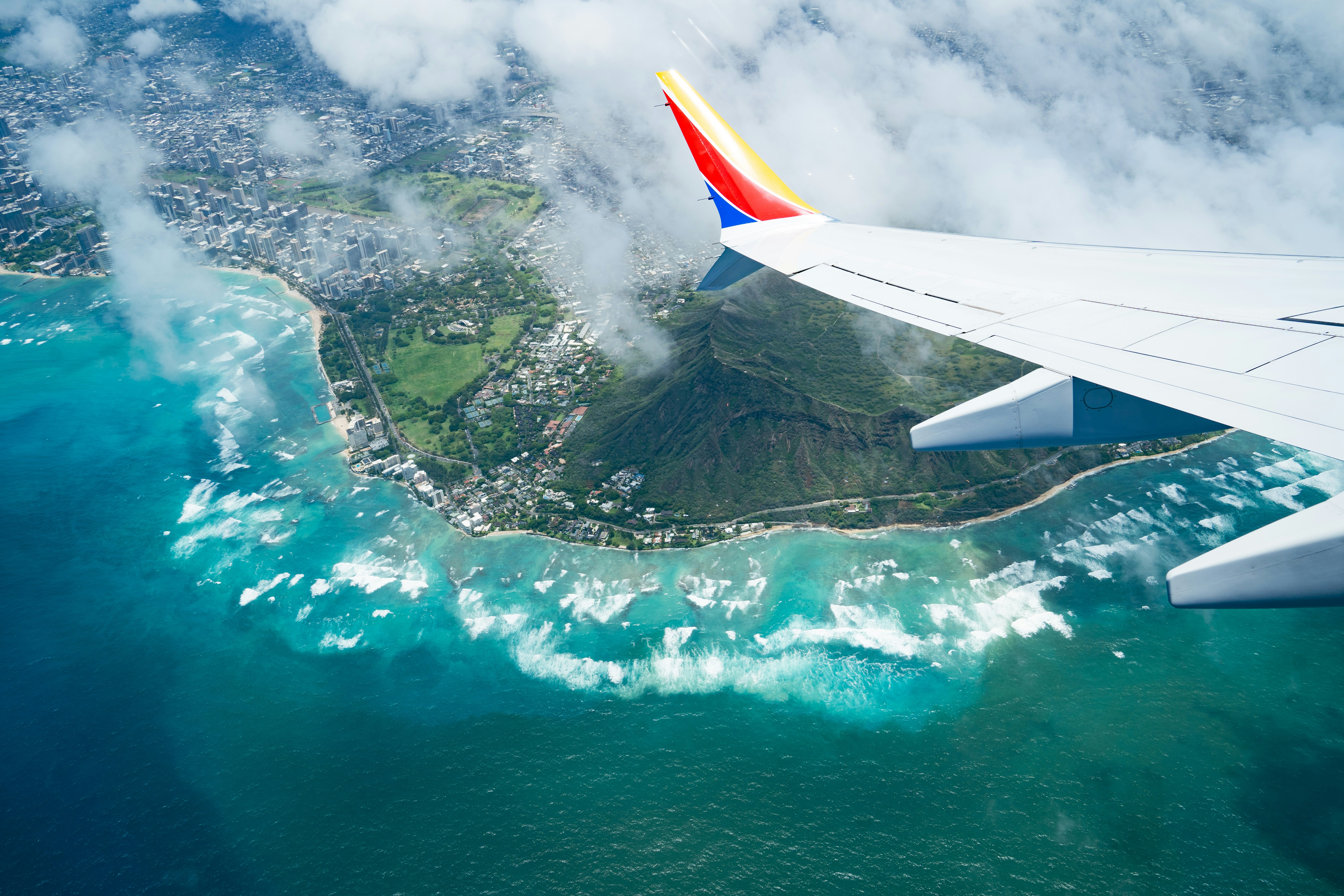 Wingtip Over a Turquoise Caldera Coastline