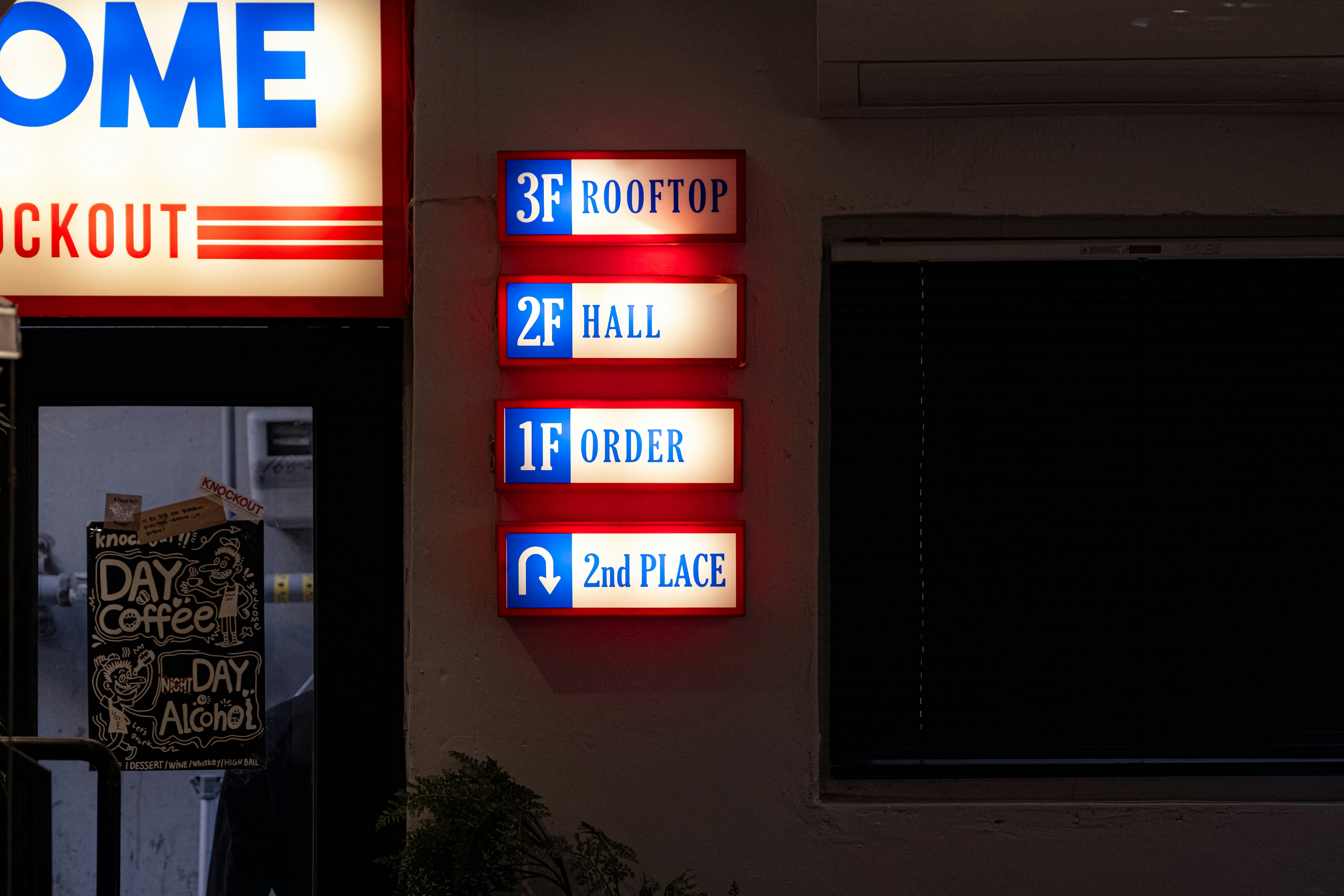 Neon Signpost in a Quiet Urban Façade