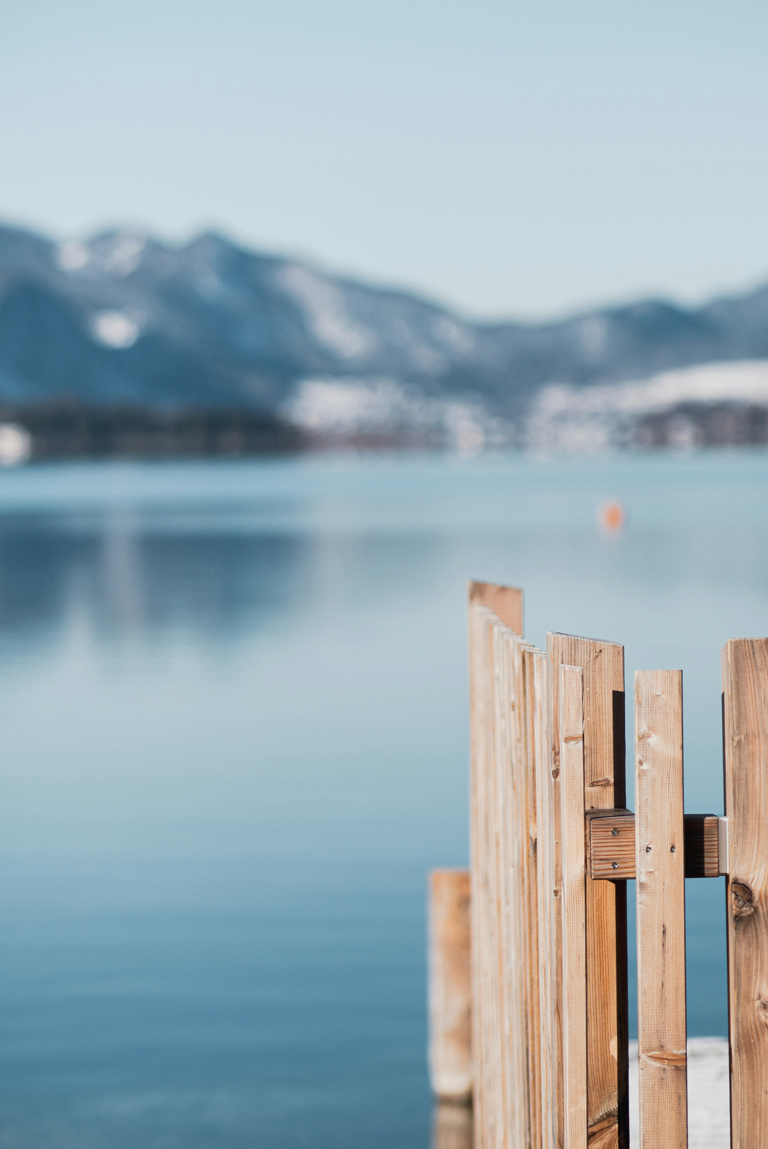 Weathered Fence at the Edge of a Glassy Alpine Lake