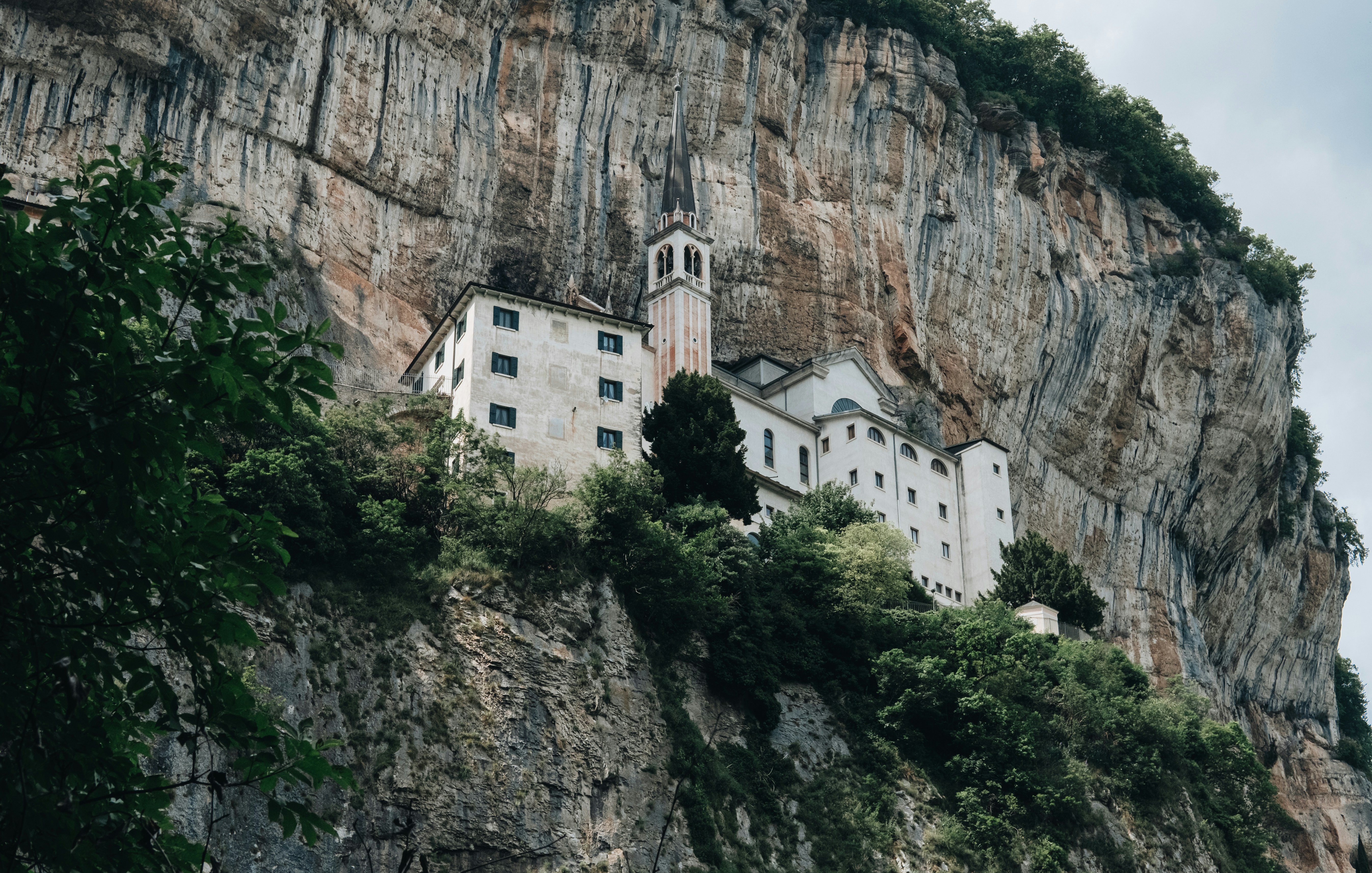 A white building on a cliff with a steep cliff behind it photo – Free ...