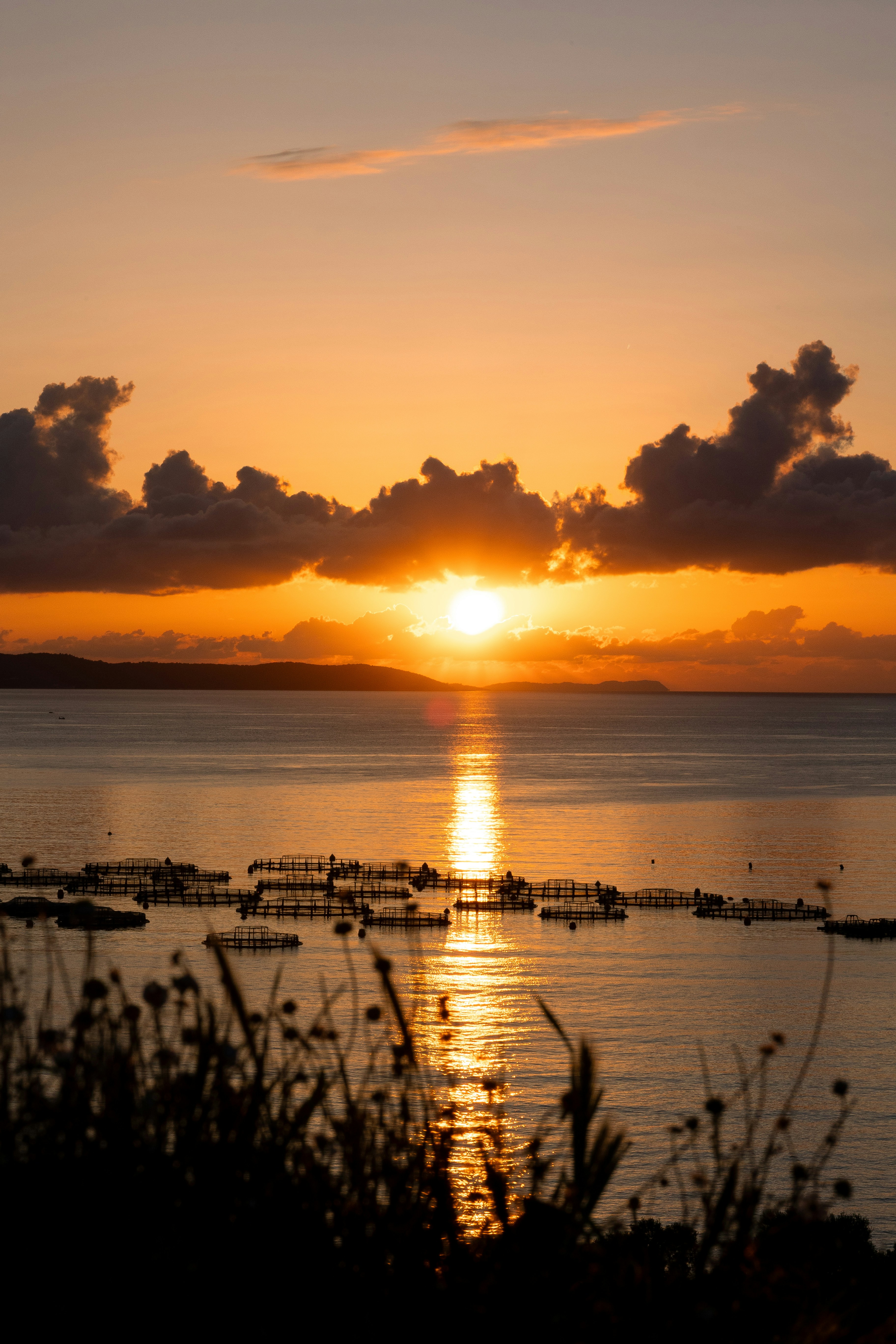 Atardecer en Albania enfrente del mar | a sunset over a body of water with clouds in the sky