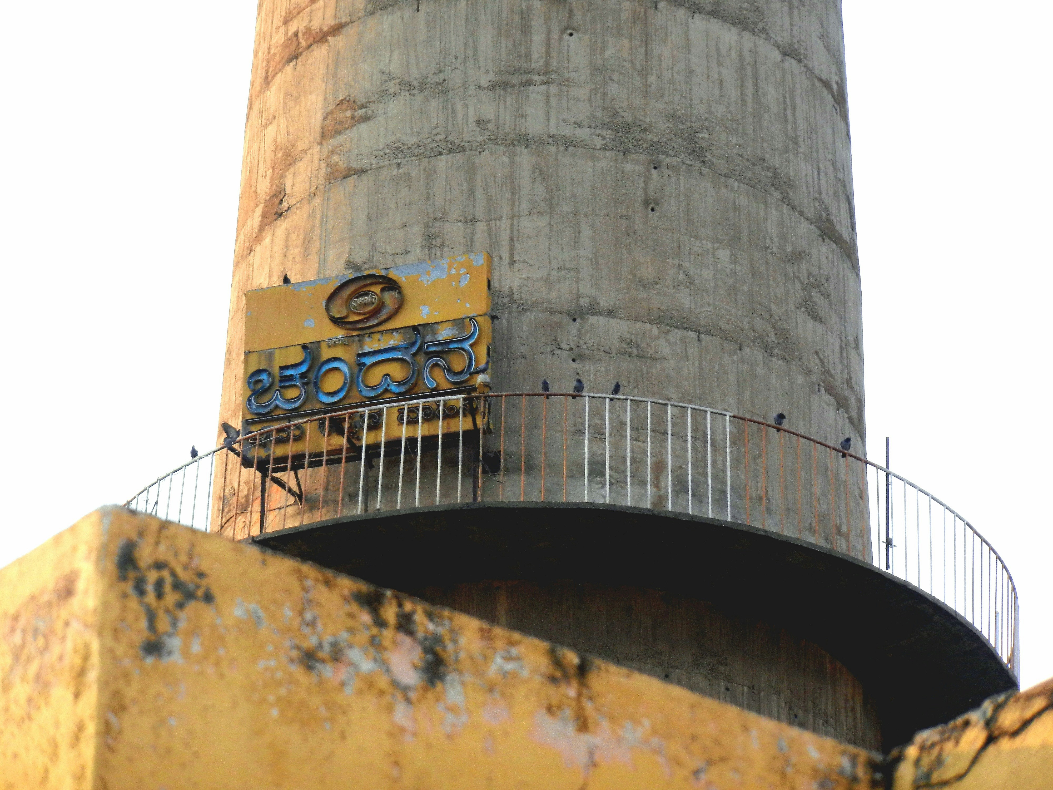 Concrete Tower sentinel: weathered signage above a curved balcony